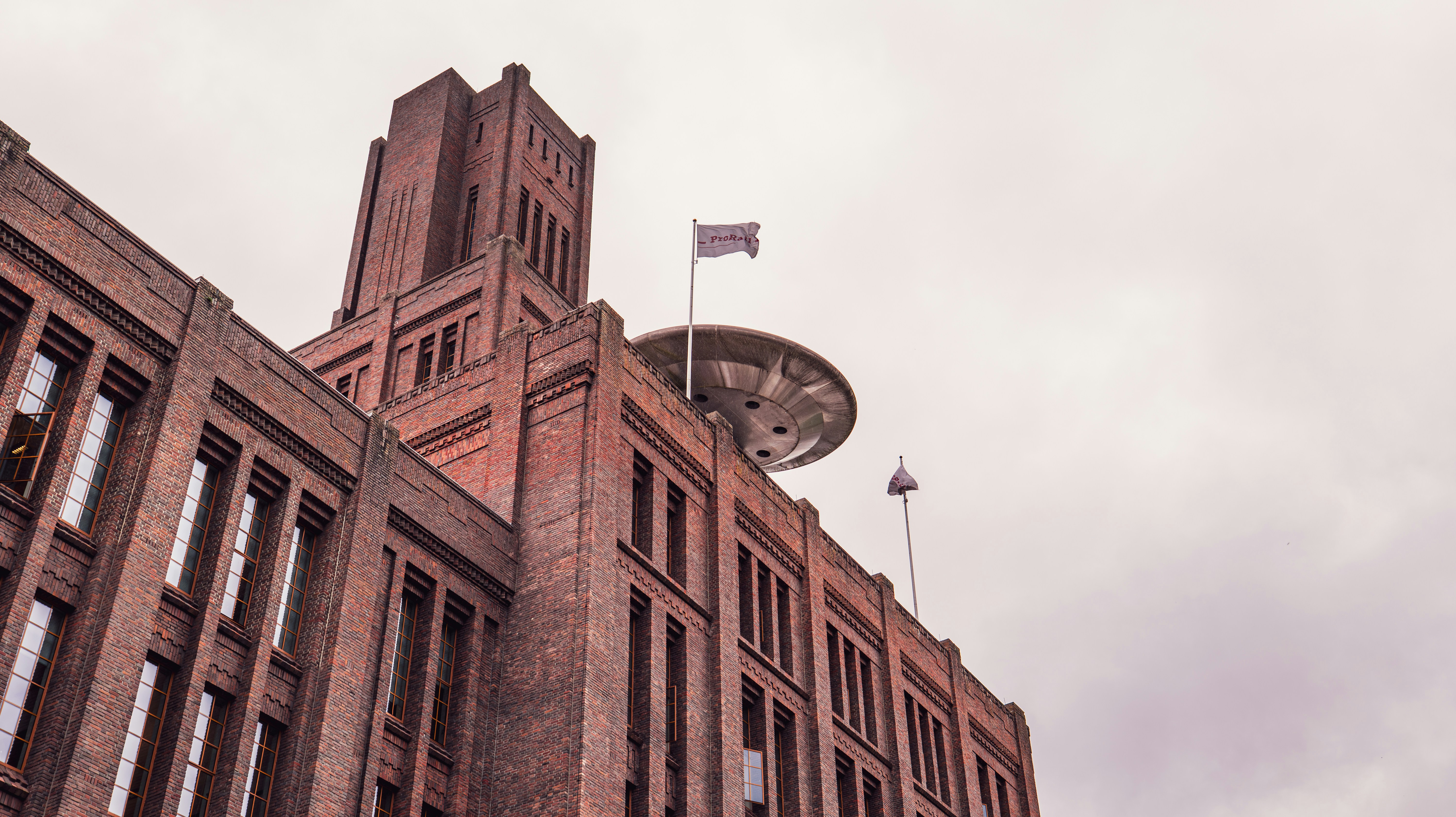 Brick Skies: Rooftop Antenna and Tower Piercing a Pale Horizon
