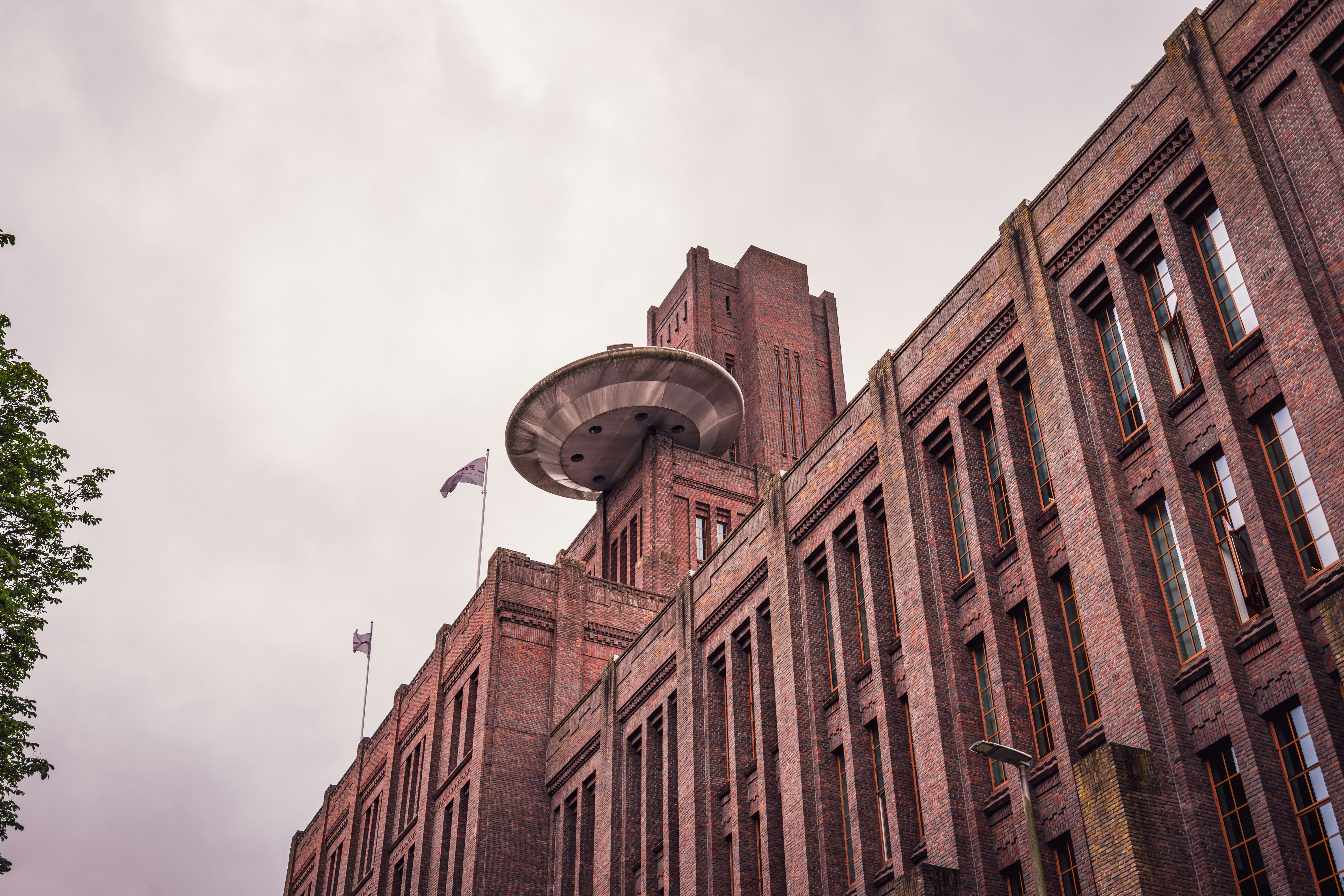 Brick towers and a saucer-shaped beacon rise against a moody sky
