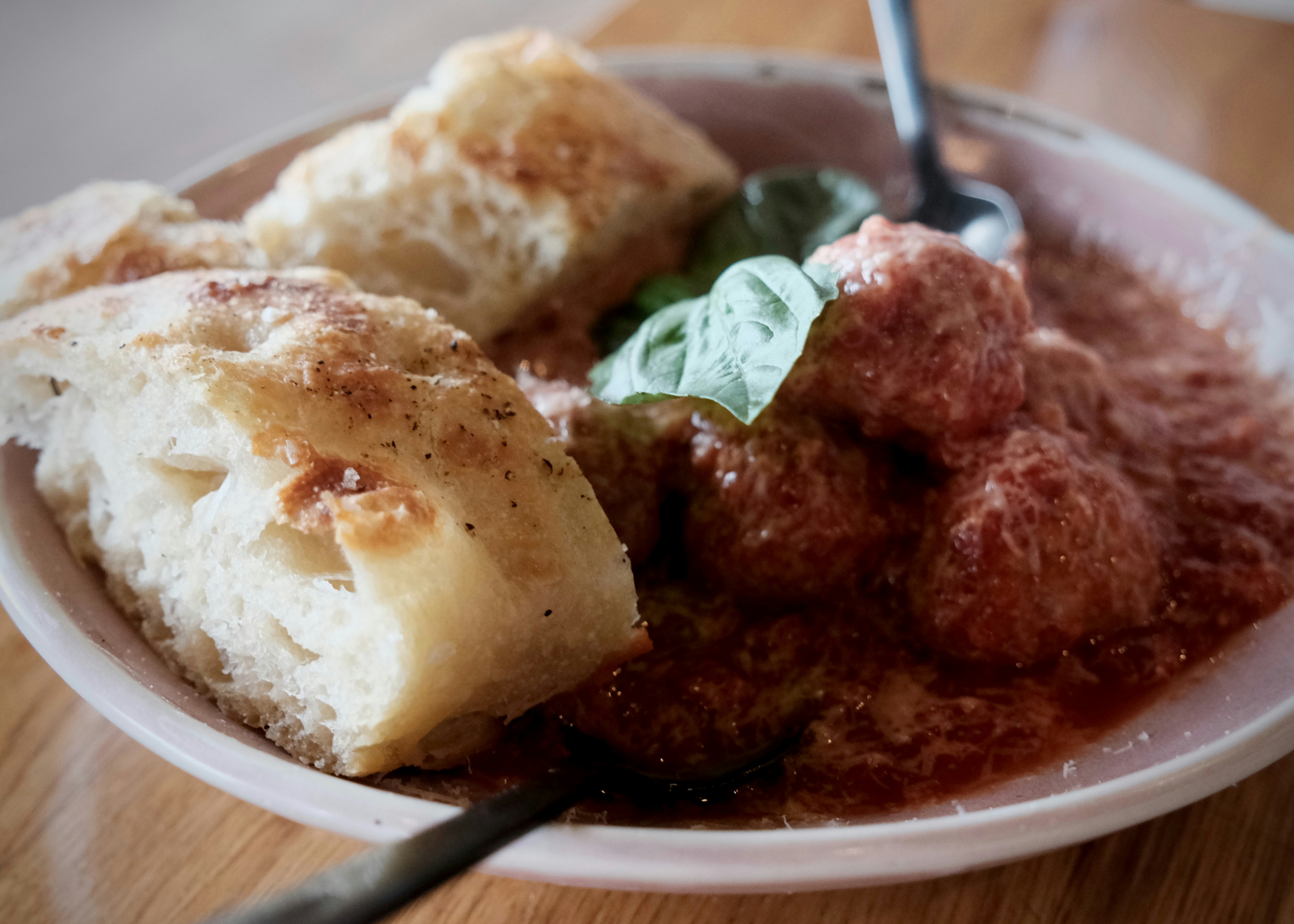 Tomato-basil braised meat with garlic bread in a shallow bowl