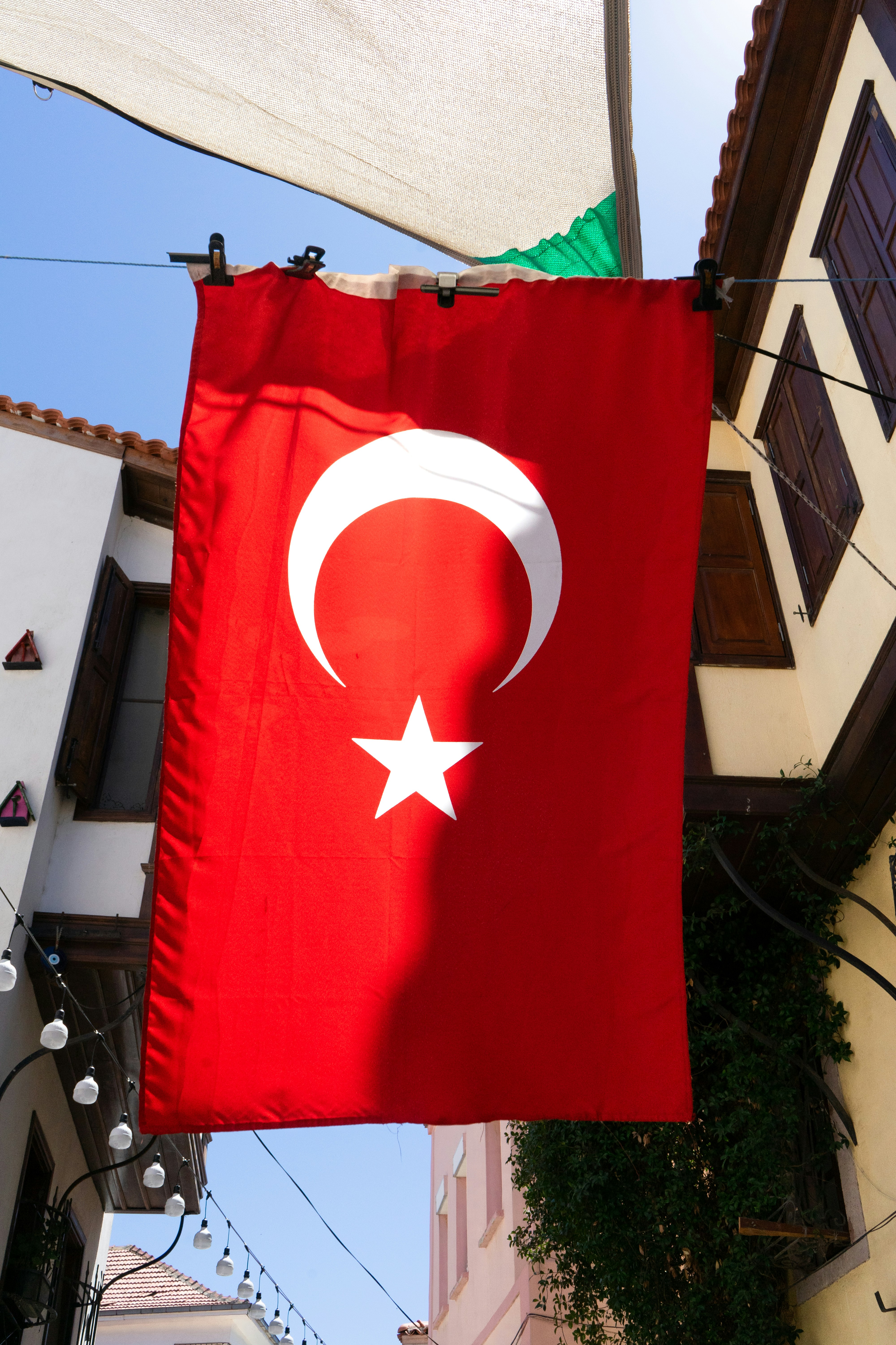 Scarlet Crescent: A Turkish Flag Draped Between Old Town Facades