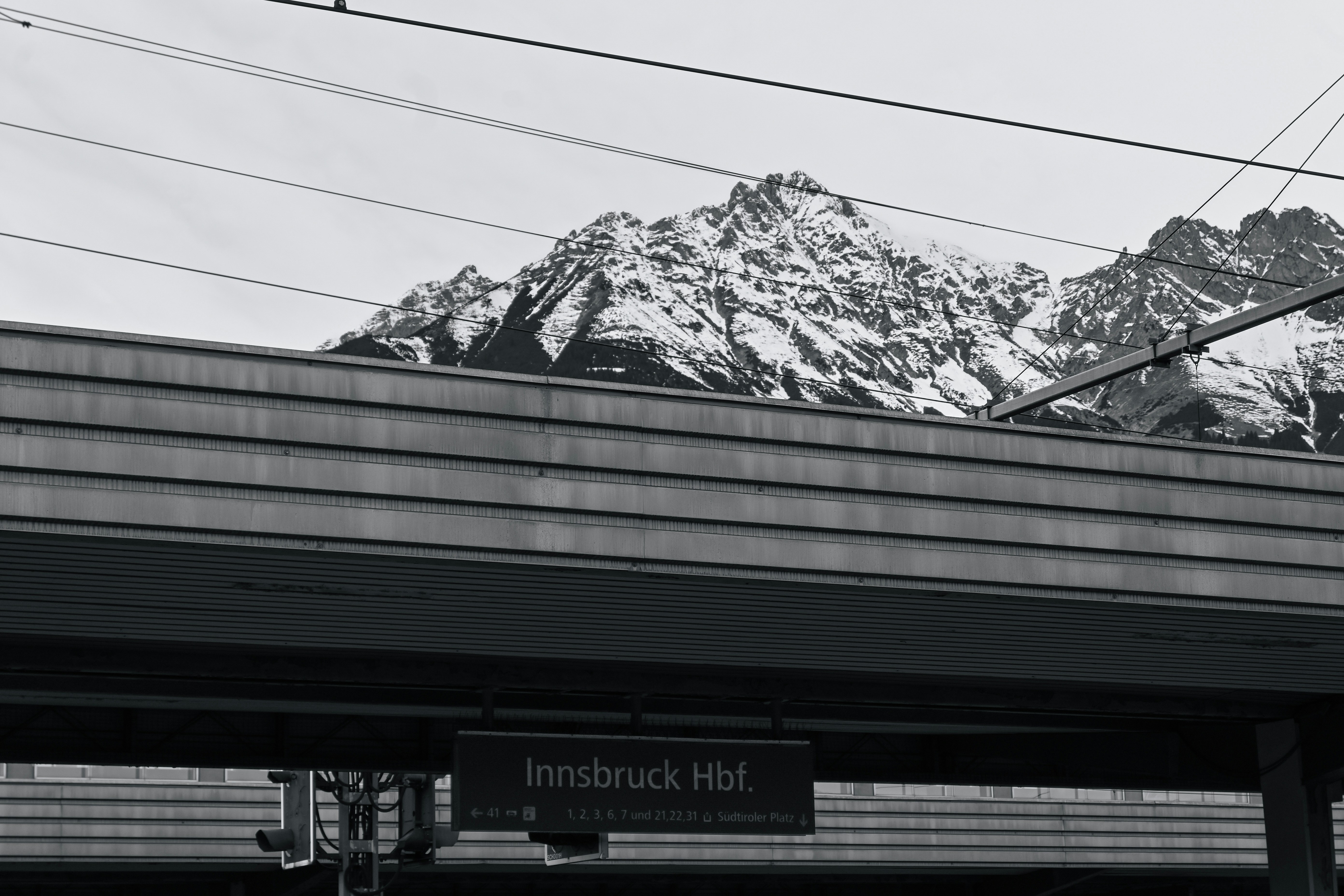 Snow-dusted Peaks over a Modern Rail Cut