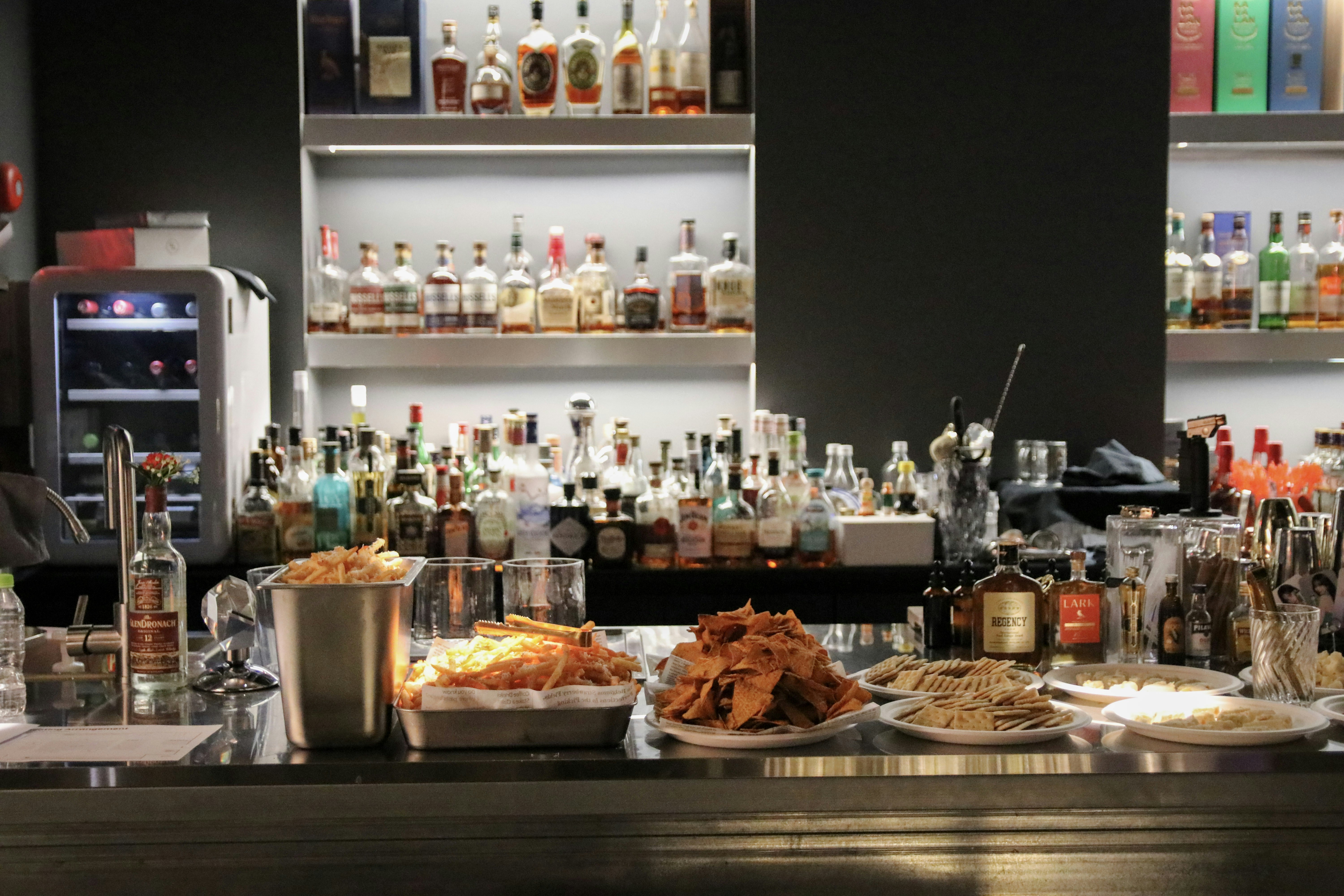 A bar counter with drinks and food photo – Free Bar Image on Unsplash