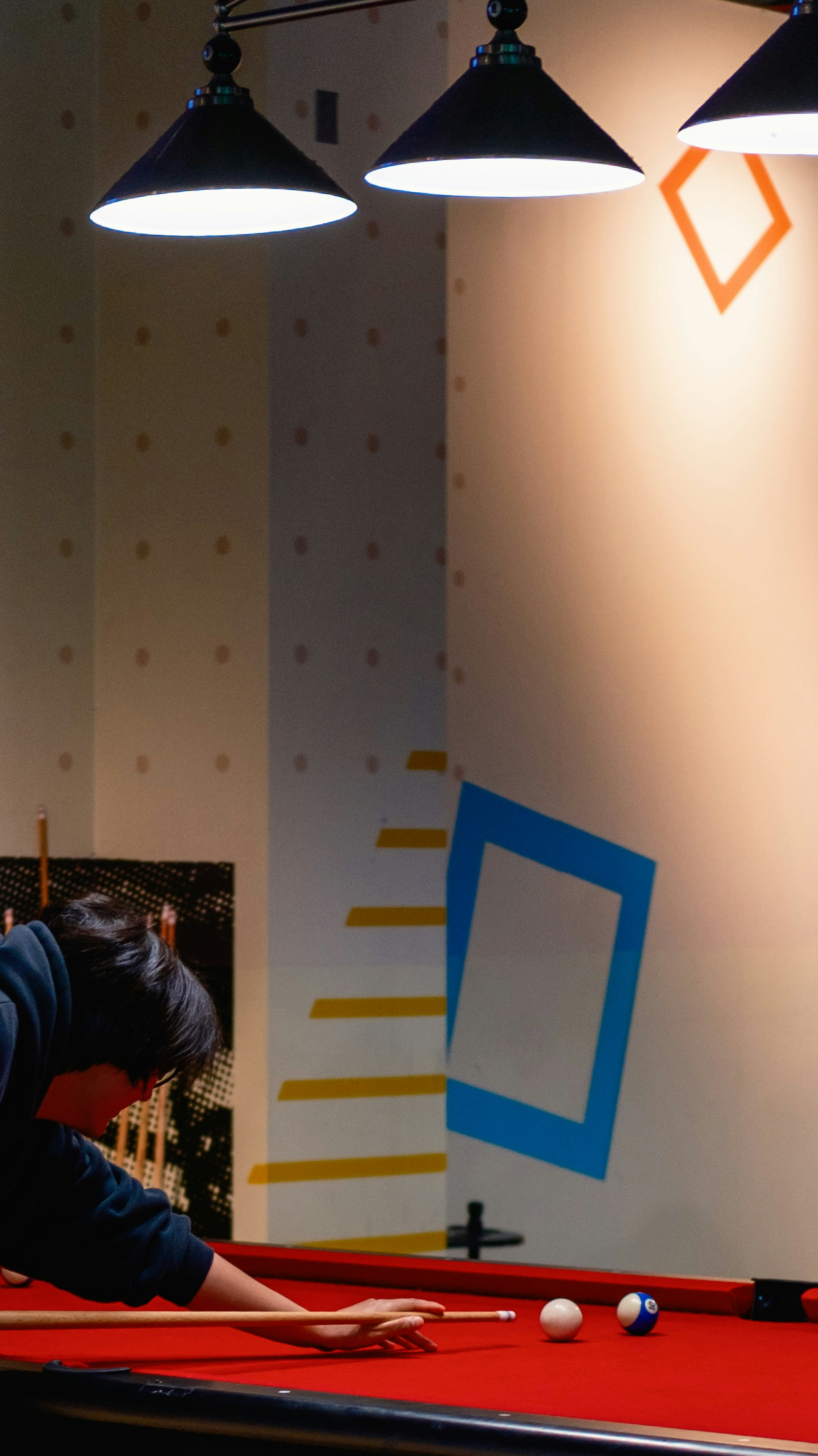 A person playing billiards on a red felt table.