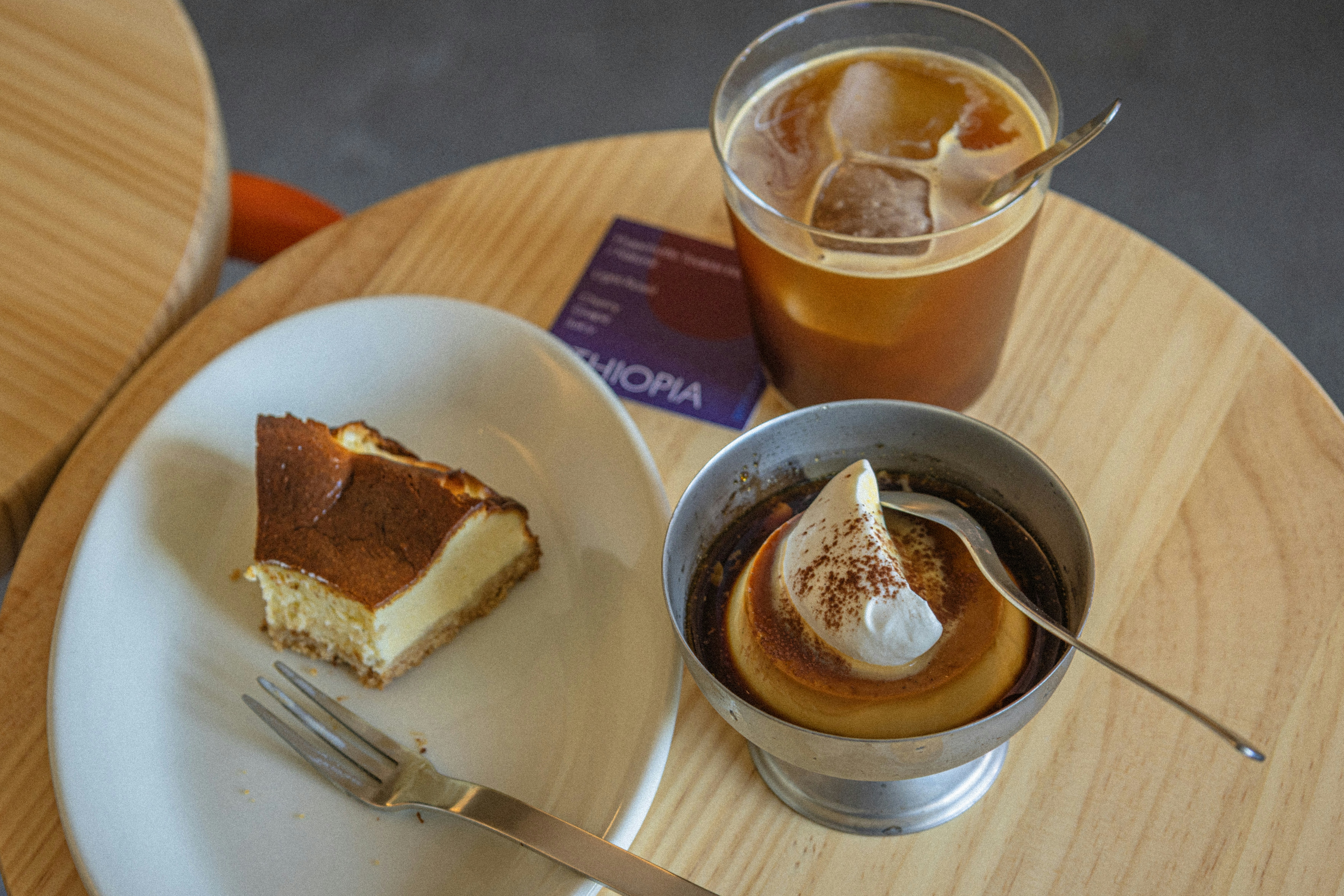 Half-eaten Cheesecake, Espresso, and Iced Coffee on a Wooden Table