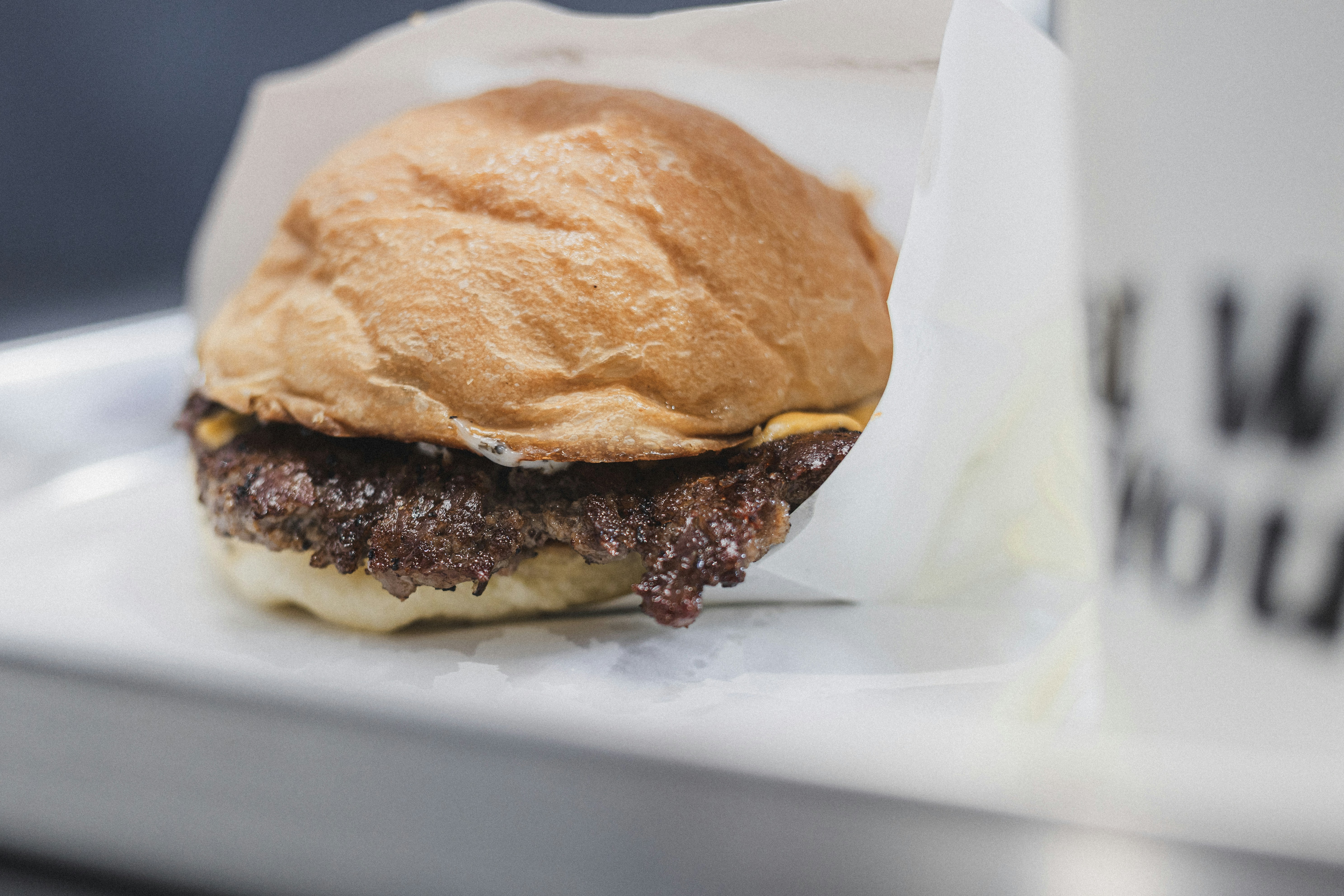 Juicy Patty at the Edge: A Close-Up of a Burger in a Minimal Wrapper