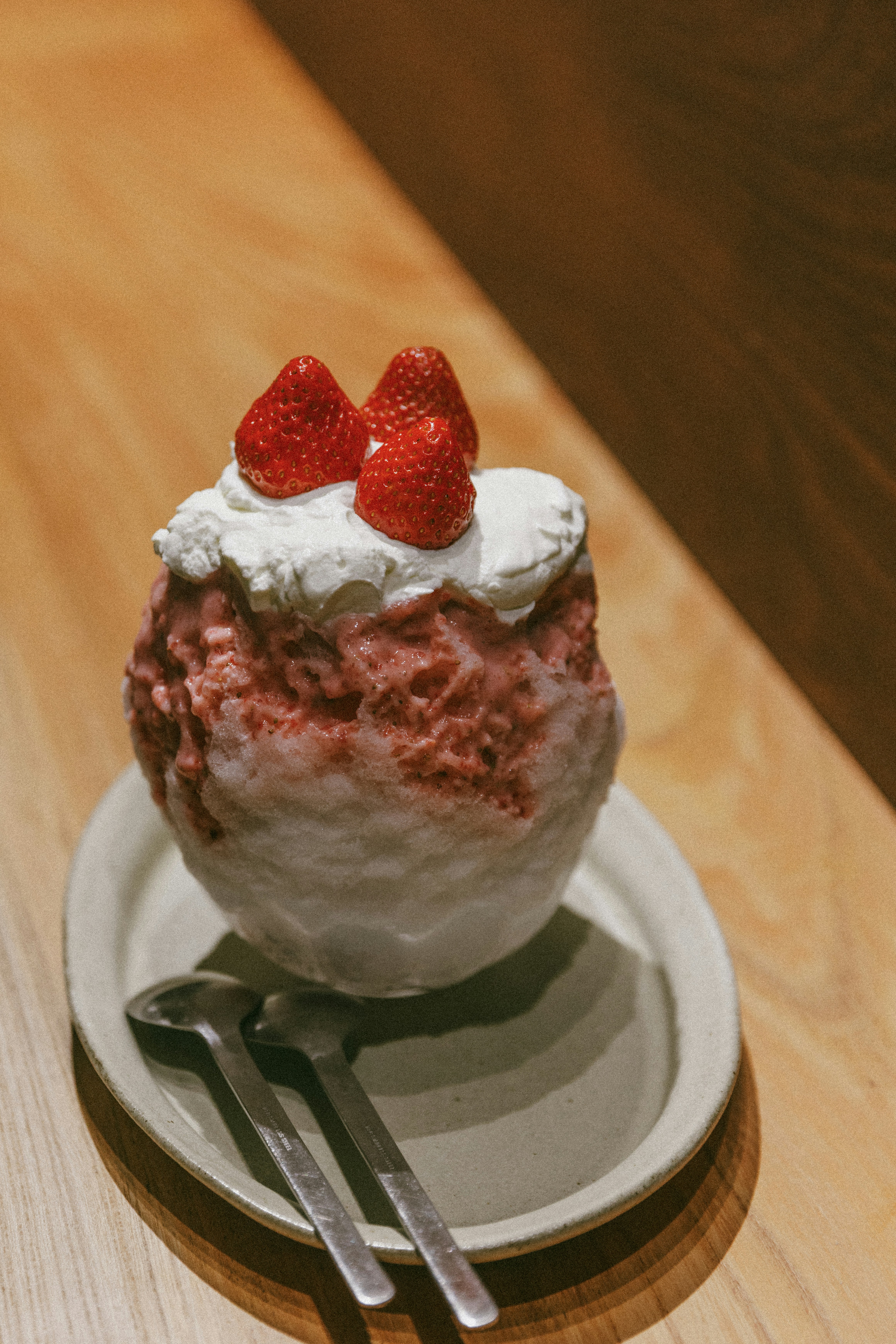 Cherry Crown: A Single Scoop of Strawberry Ice Cream on a Wooden Route