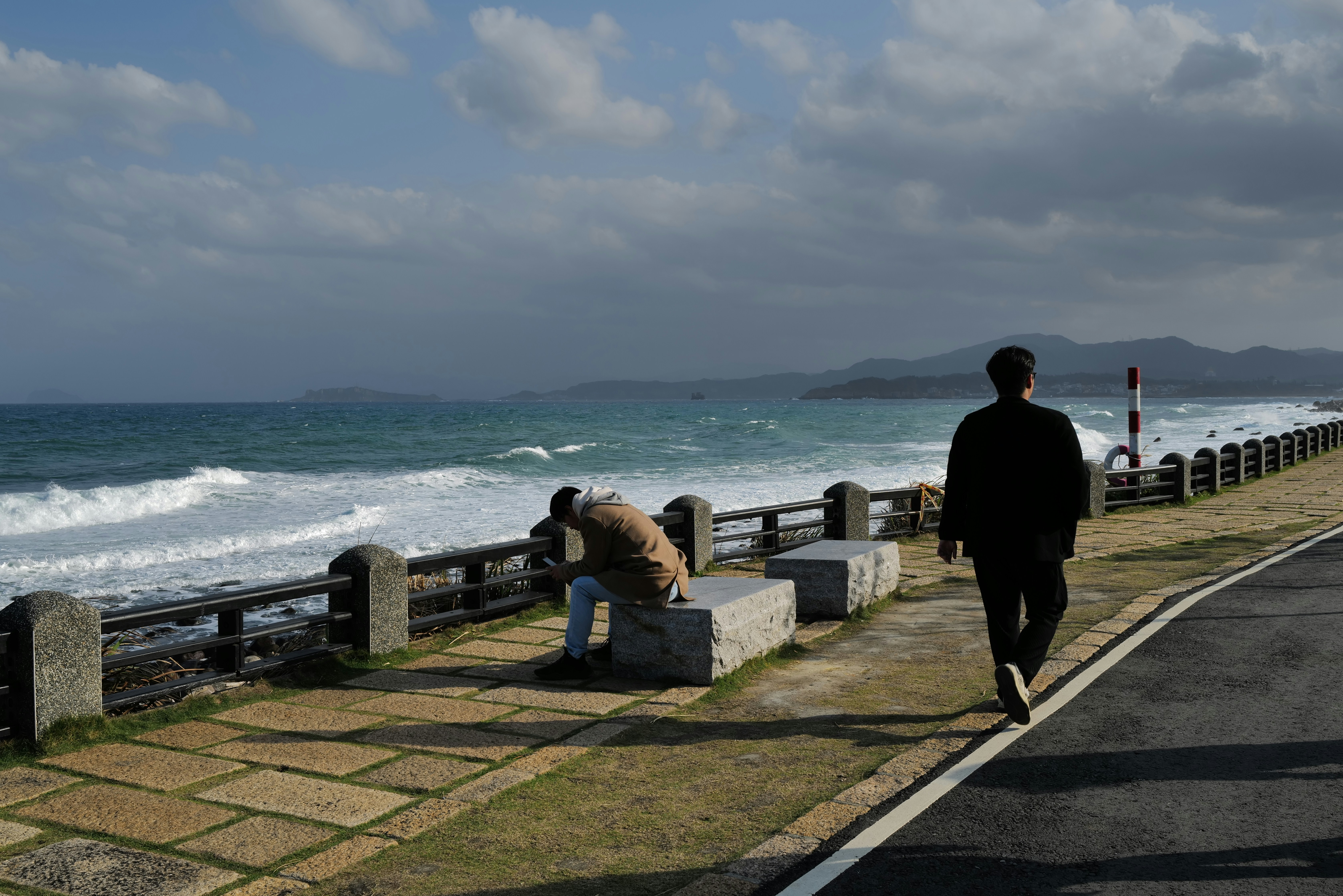 Quiet Walk by the Sea: silhouette on the promenade