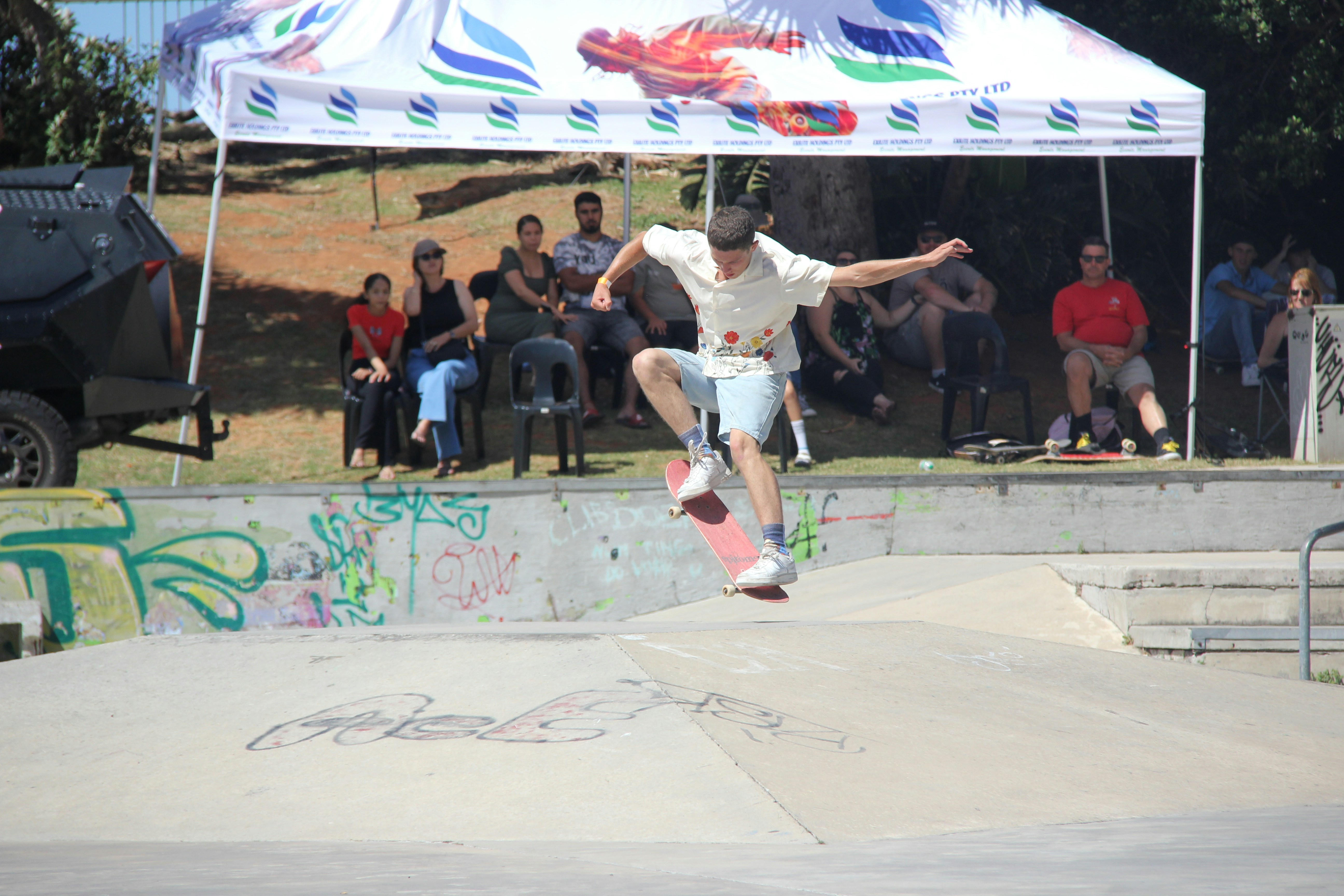 Altitude Above the Concrete: A Skateboarder Catches Air Beneath a Graffiti-Stamped Sky