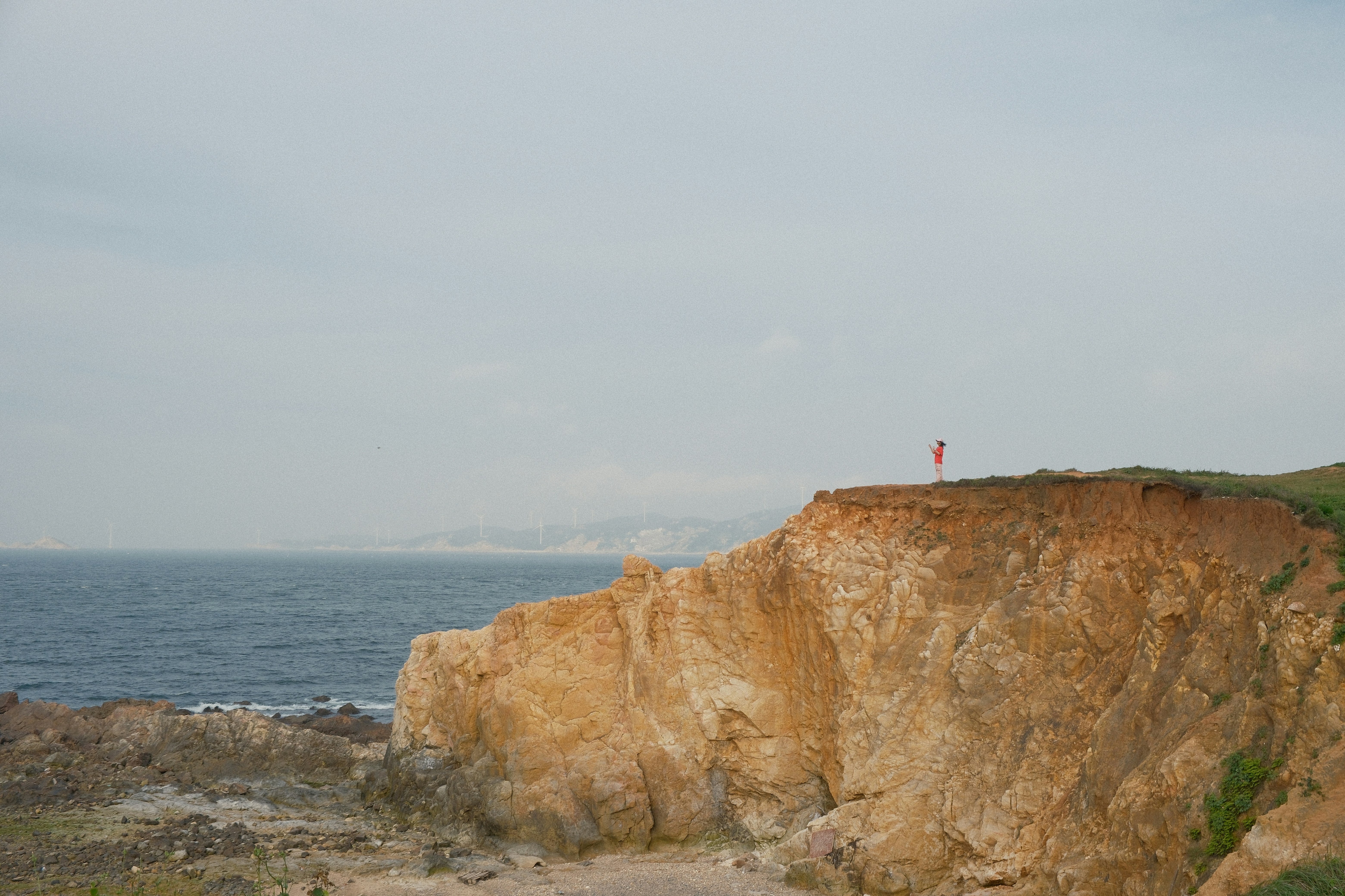 Top Edge Sentinel: A Lone Figure on the Cliff