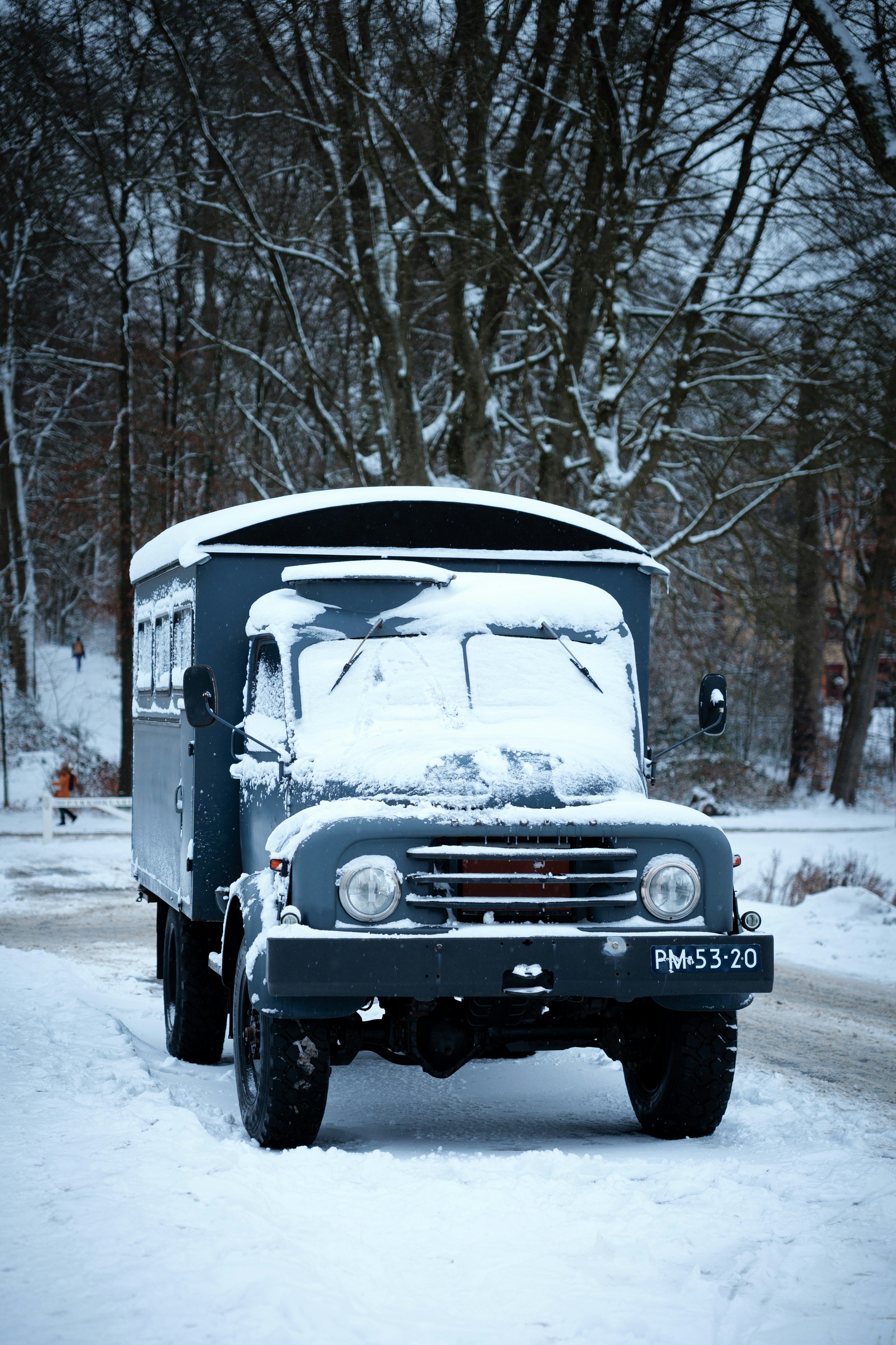 Snowbound Workhorse: A Vintage Truck Stands Guard in a Quiet Park