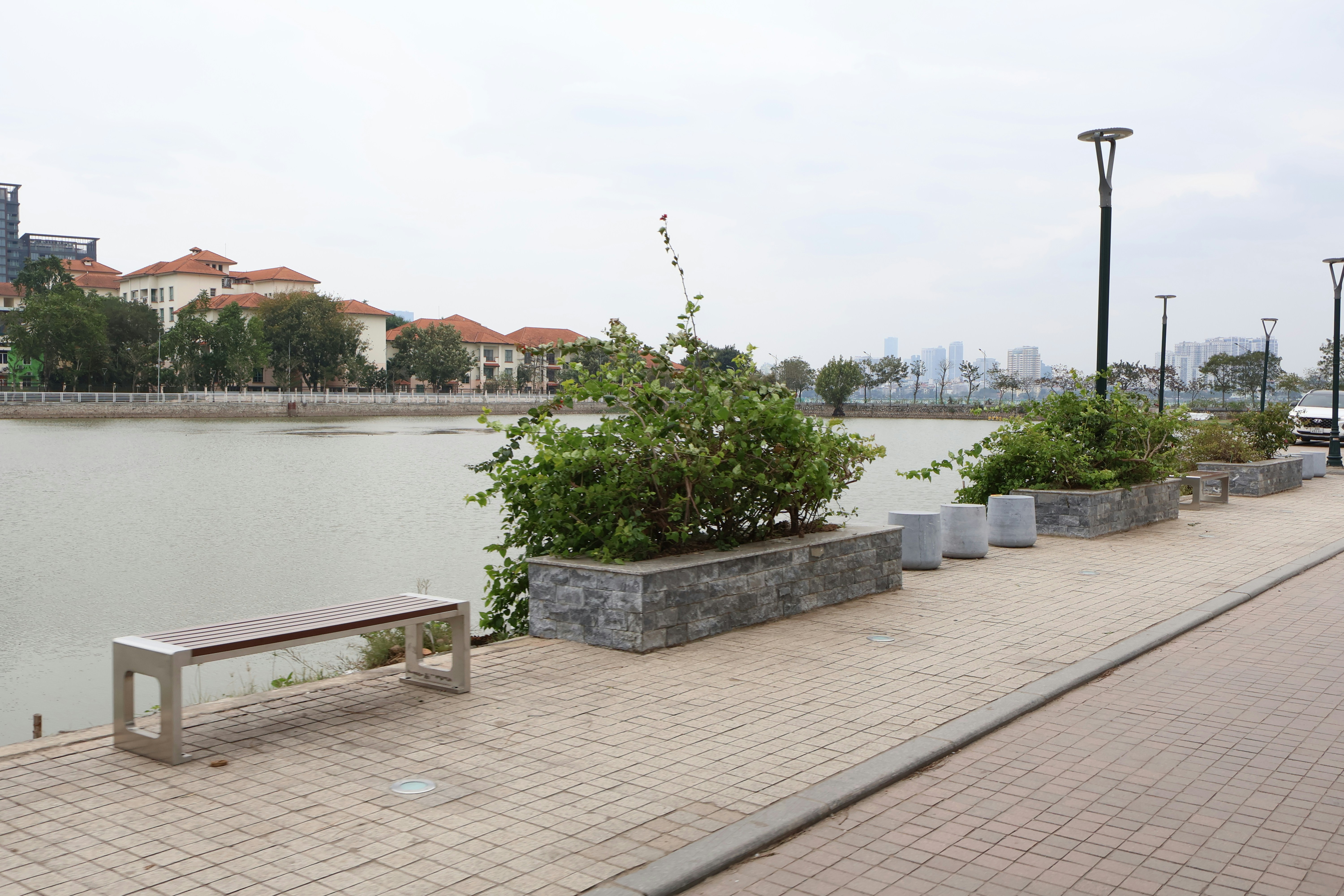 Quiet riverside promenade with planters and benches