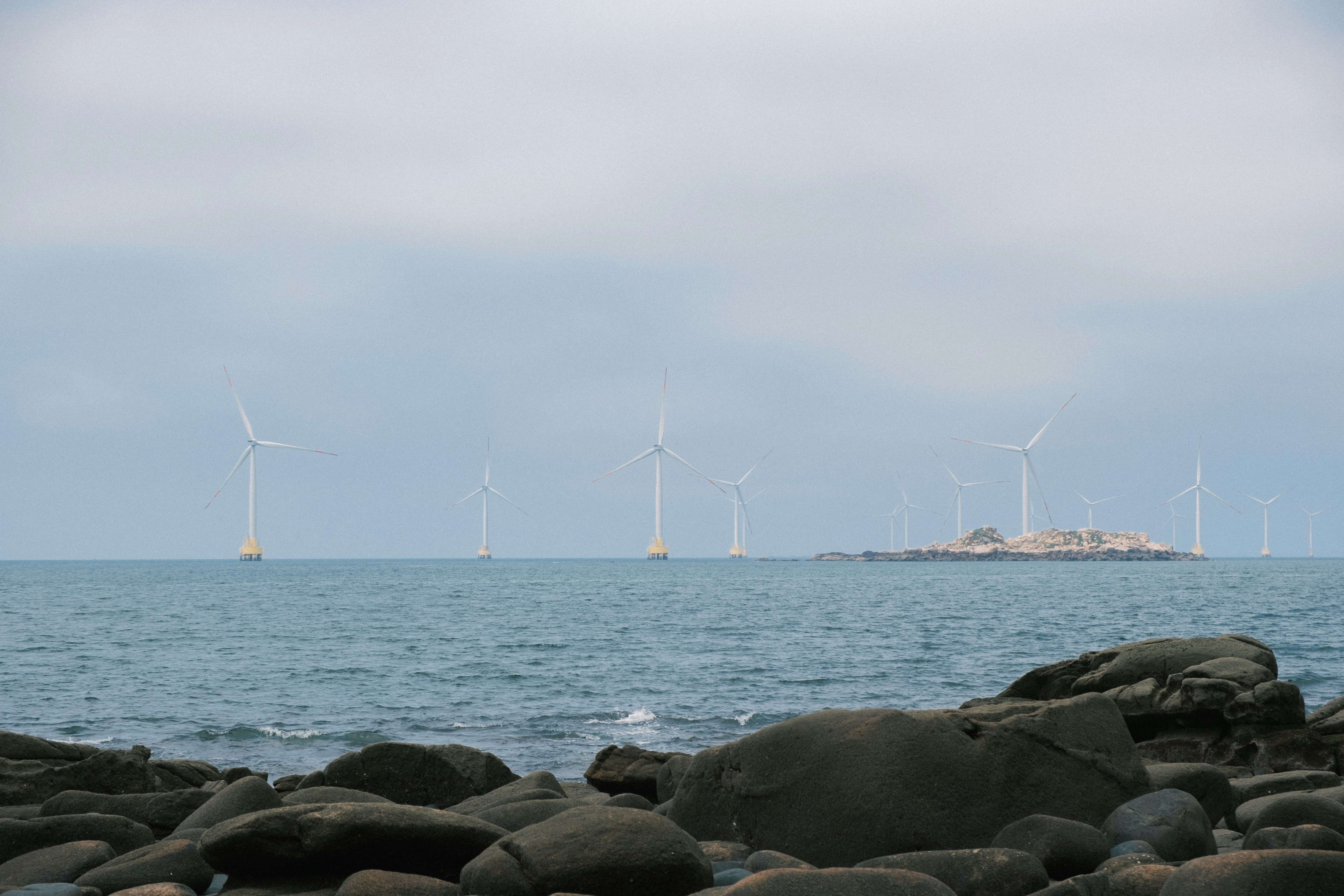 Windward Horizon: Wind Turbines Beyond the rocky shoreline