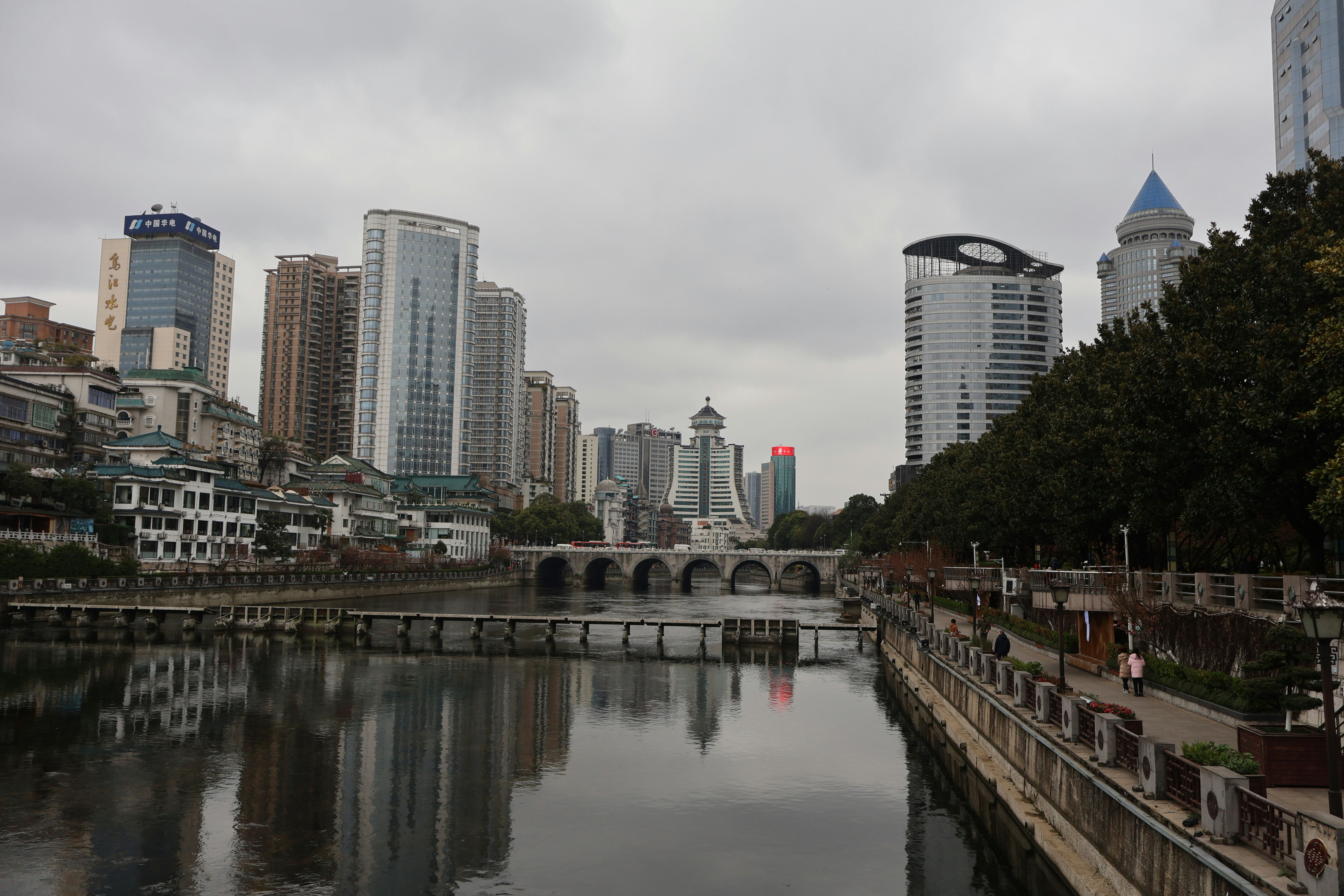 Bridge Corridor Between Modern Skyscrapers Over a Quiet River