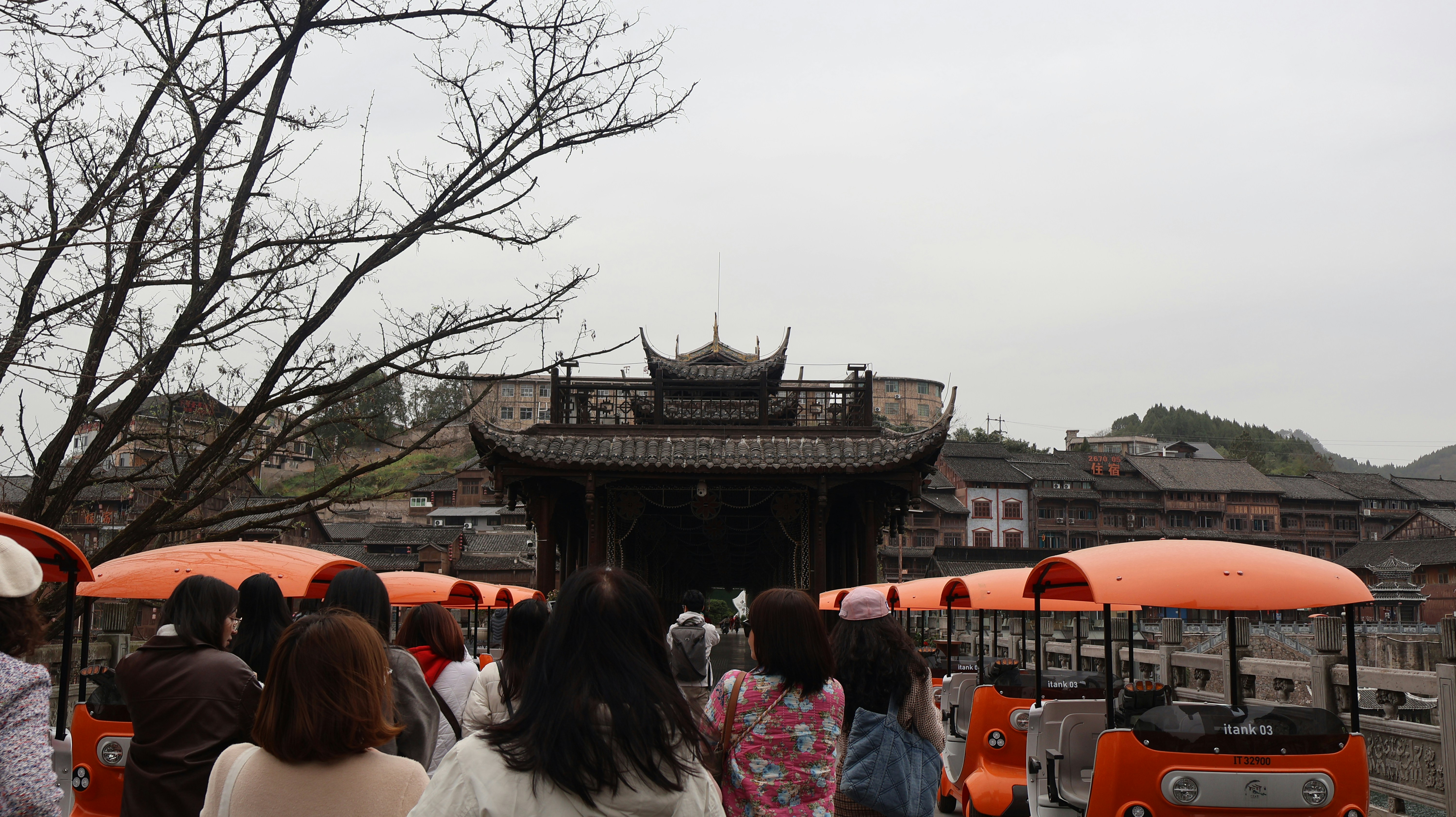 Crowded Riverside Gate with Orange Boats