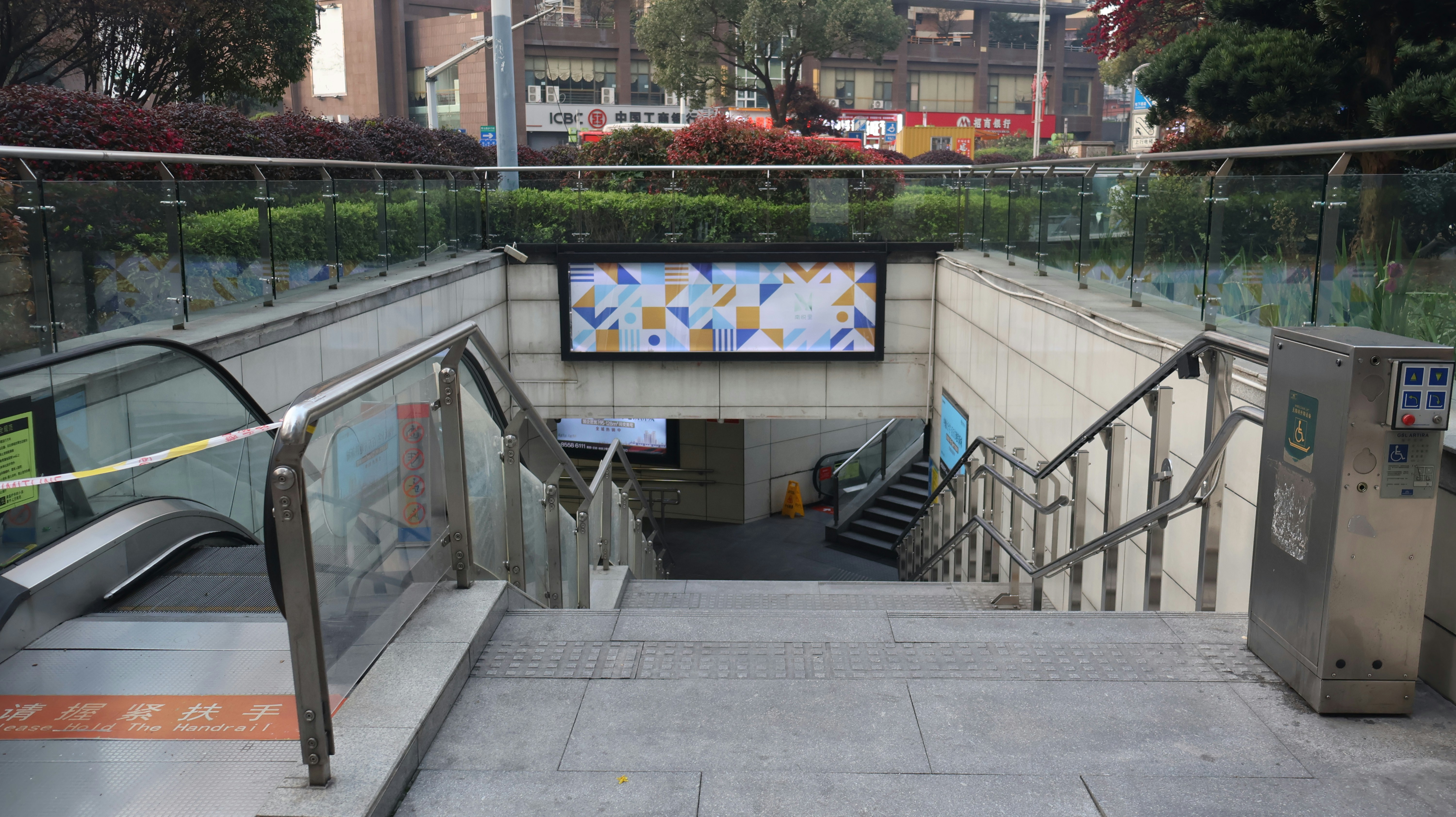 Underground Atrium: Escalator Descent Framed by Glass Railings