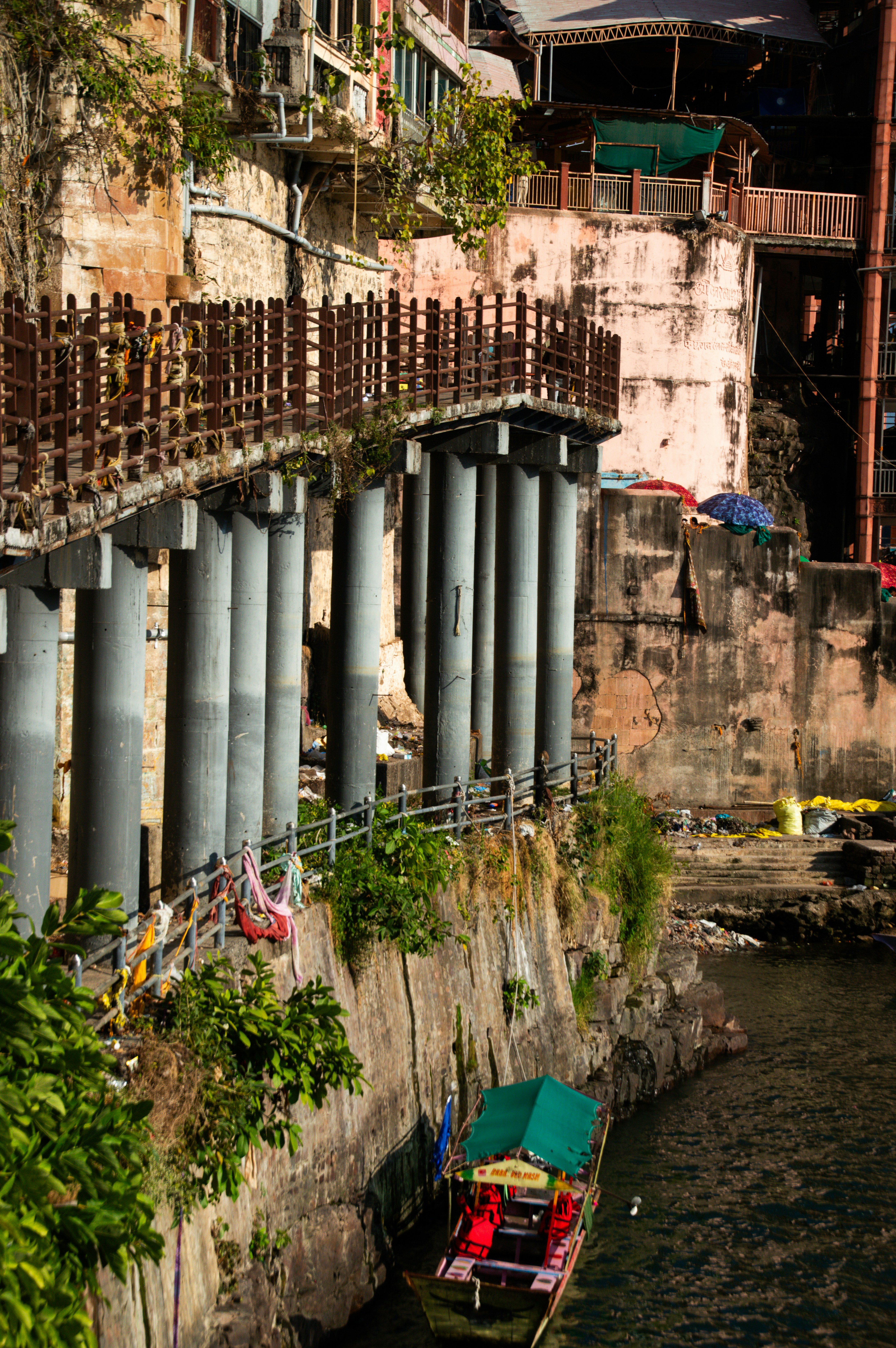 Verdant riverwalk under a weathered arcade