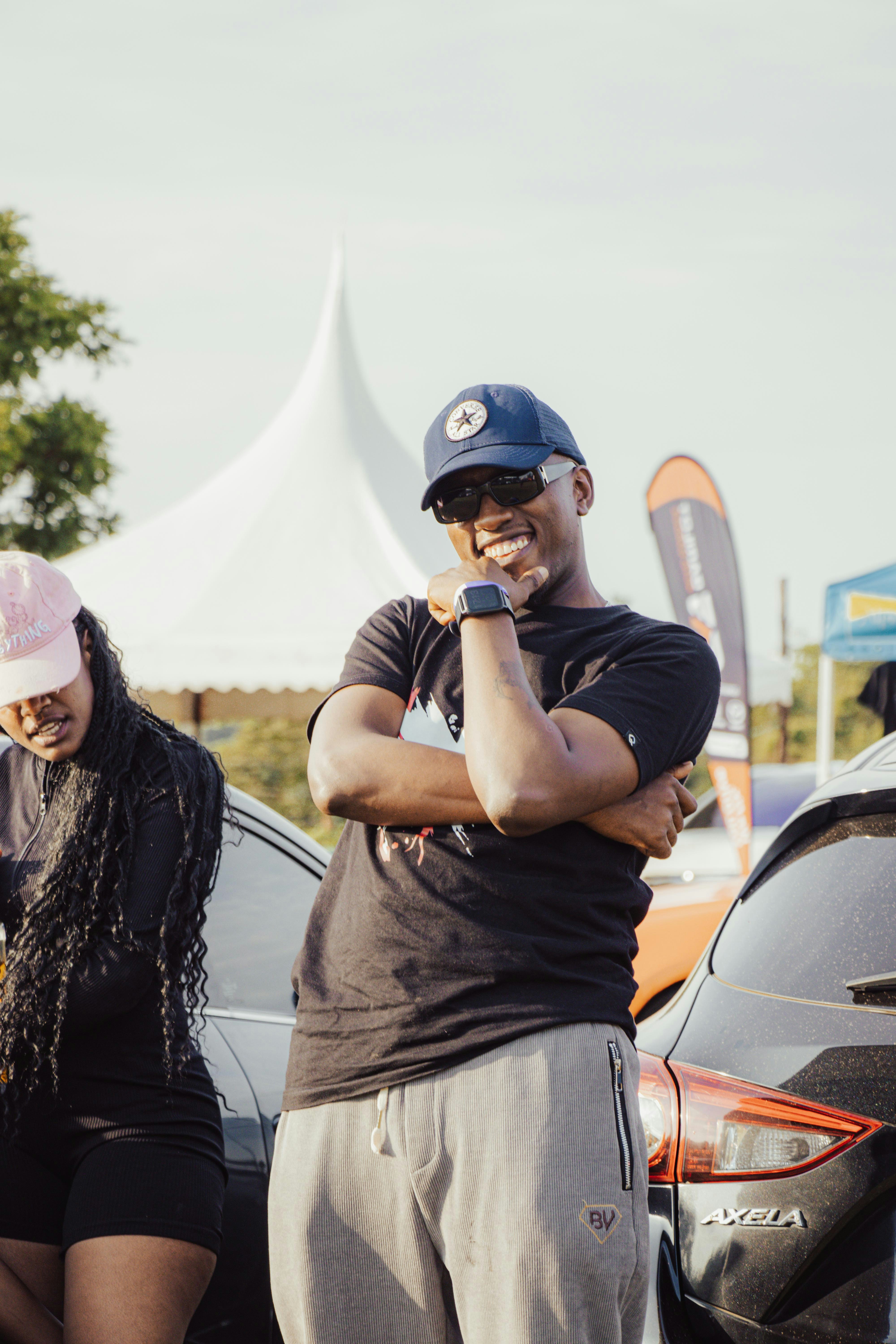 Smiling spectator in a casual pose at a car show crowd scene