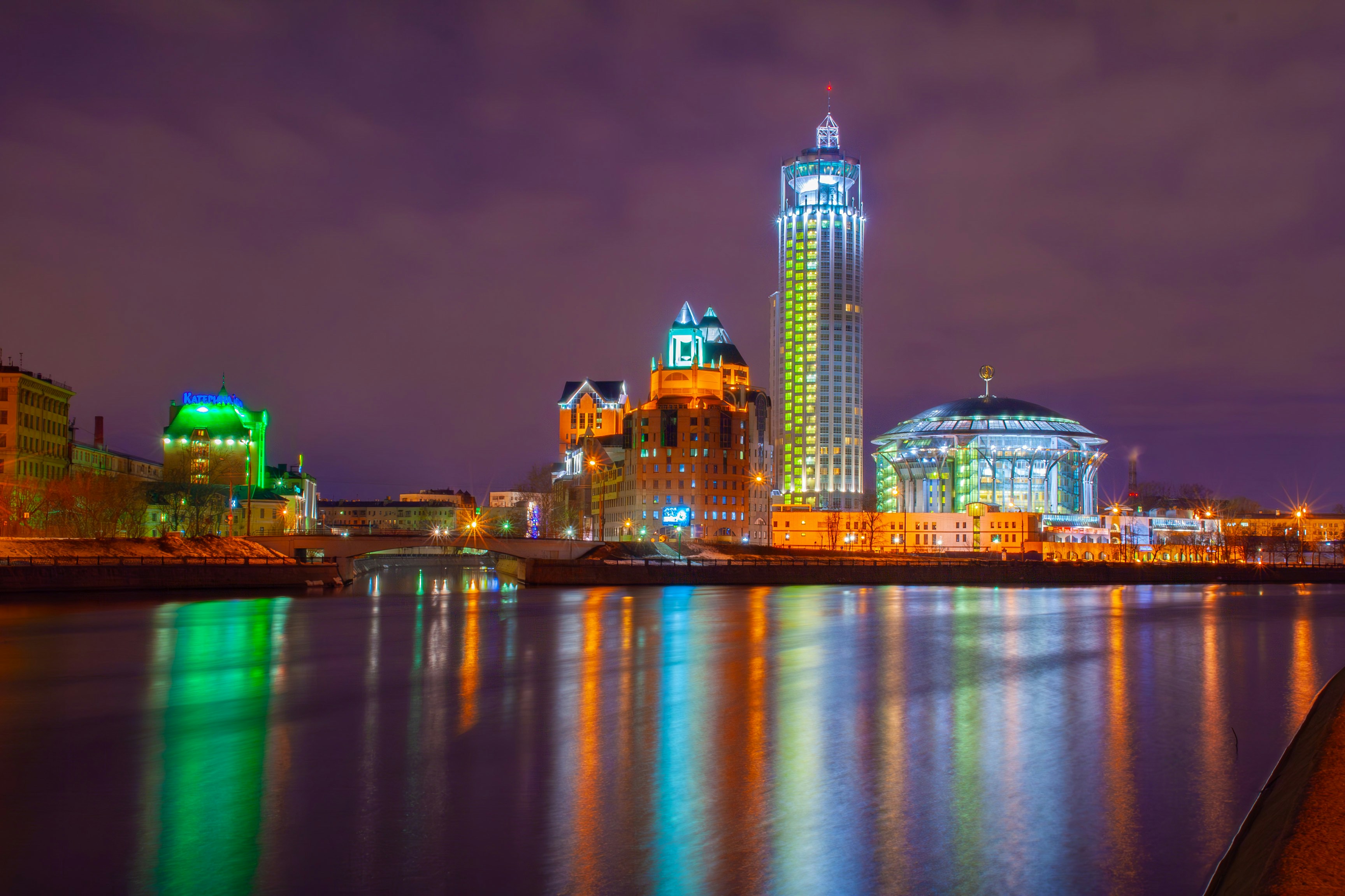 City Lights Crossing the River: Neon Reflections on the Water