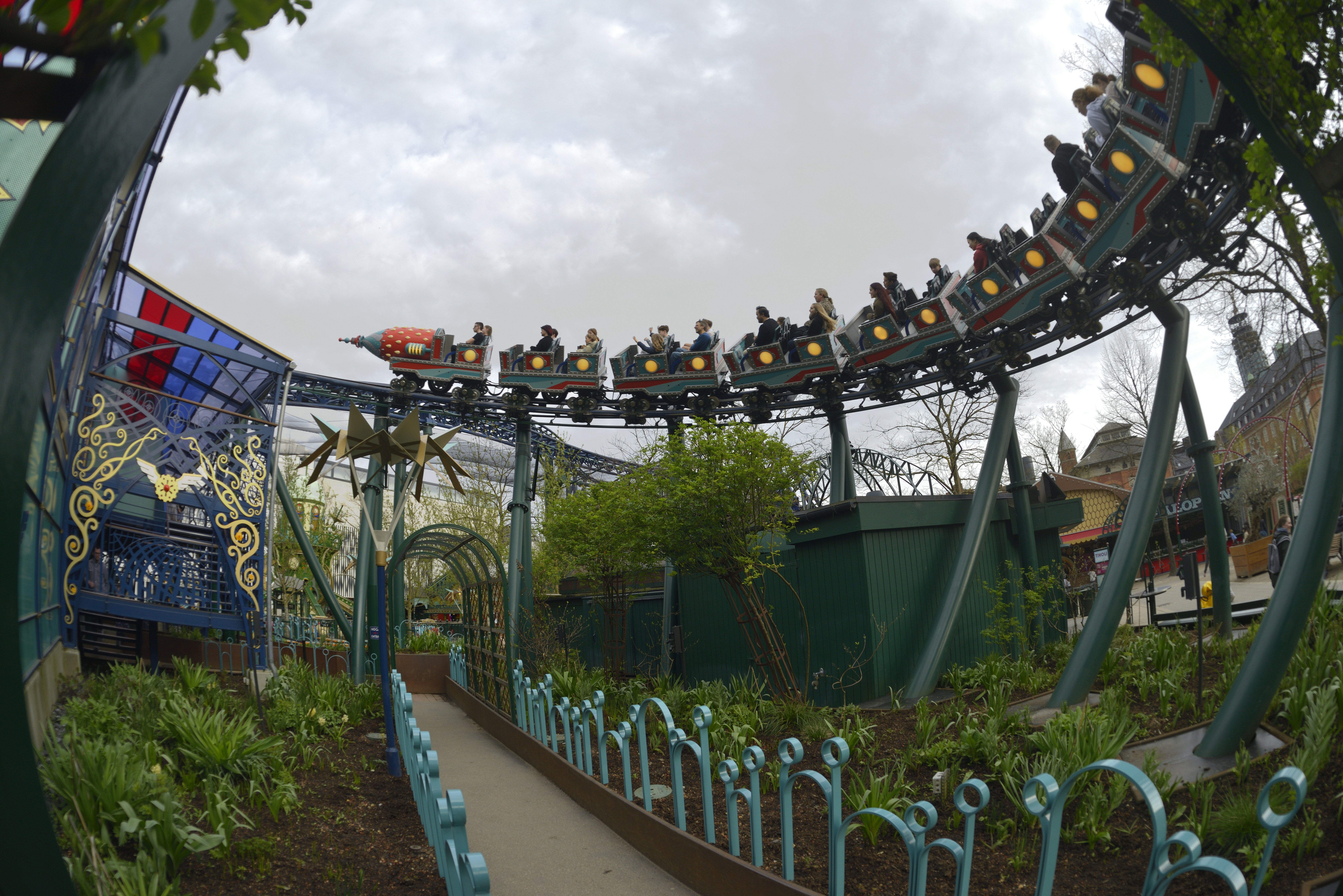 Loopy Rails in the Sky: A Winding Ride Above a Lush Green Walkway