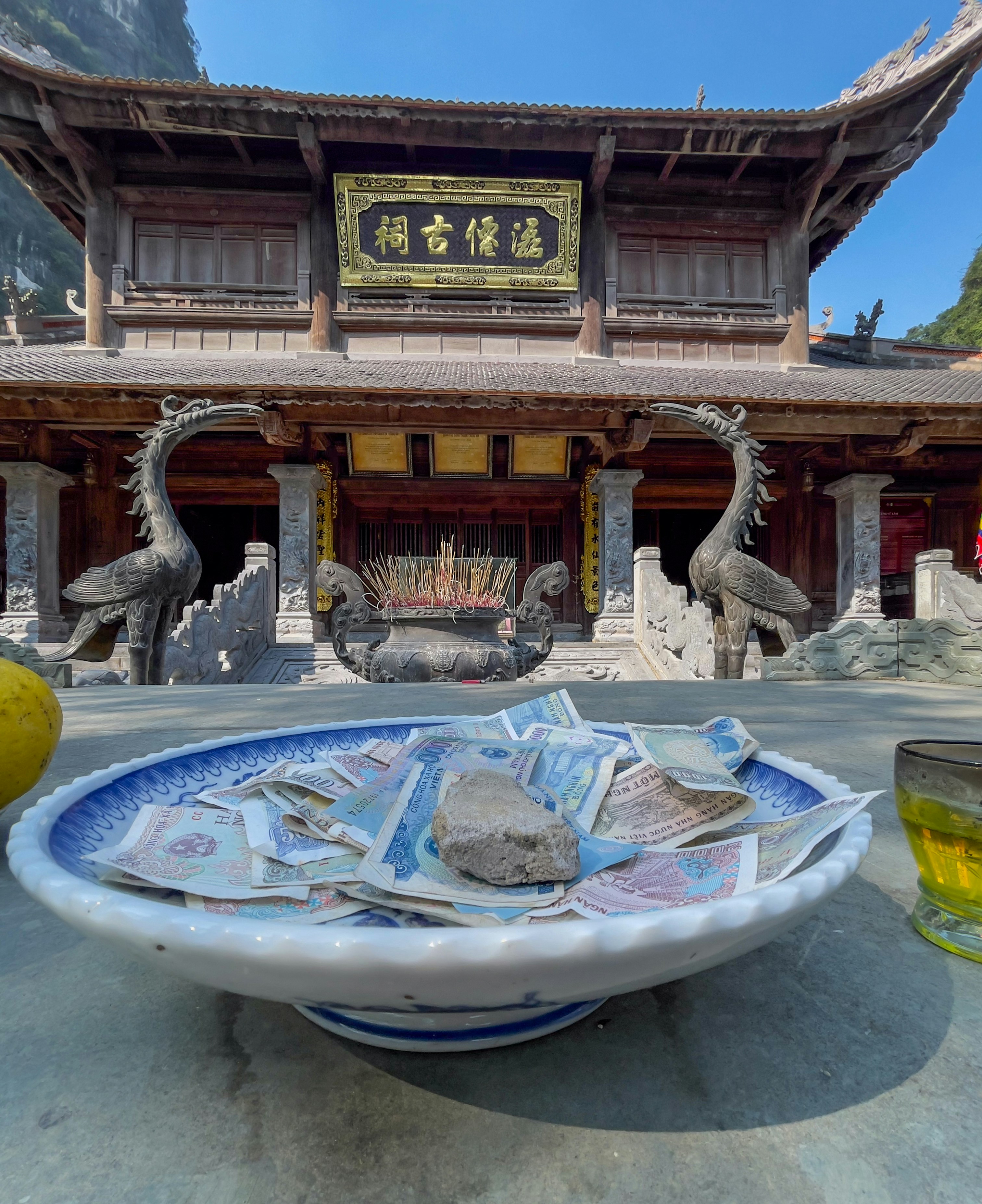 Offerings at the Temple Gate: A Bowl of Currency before the Dragon Statues