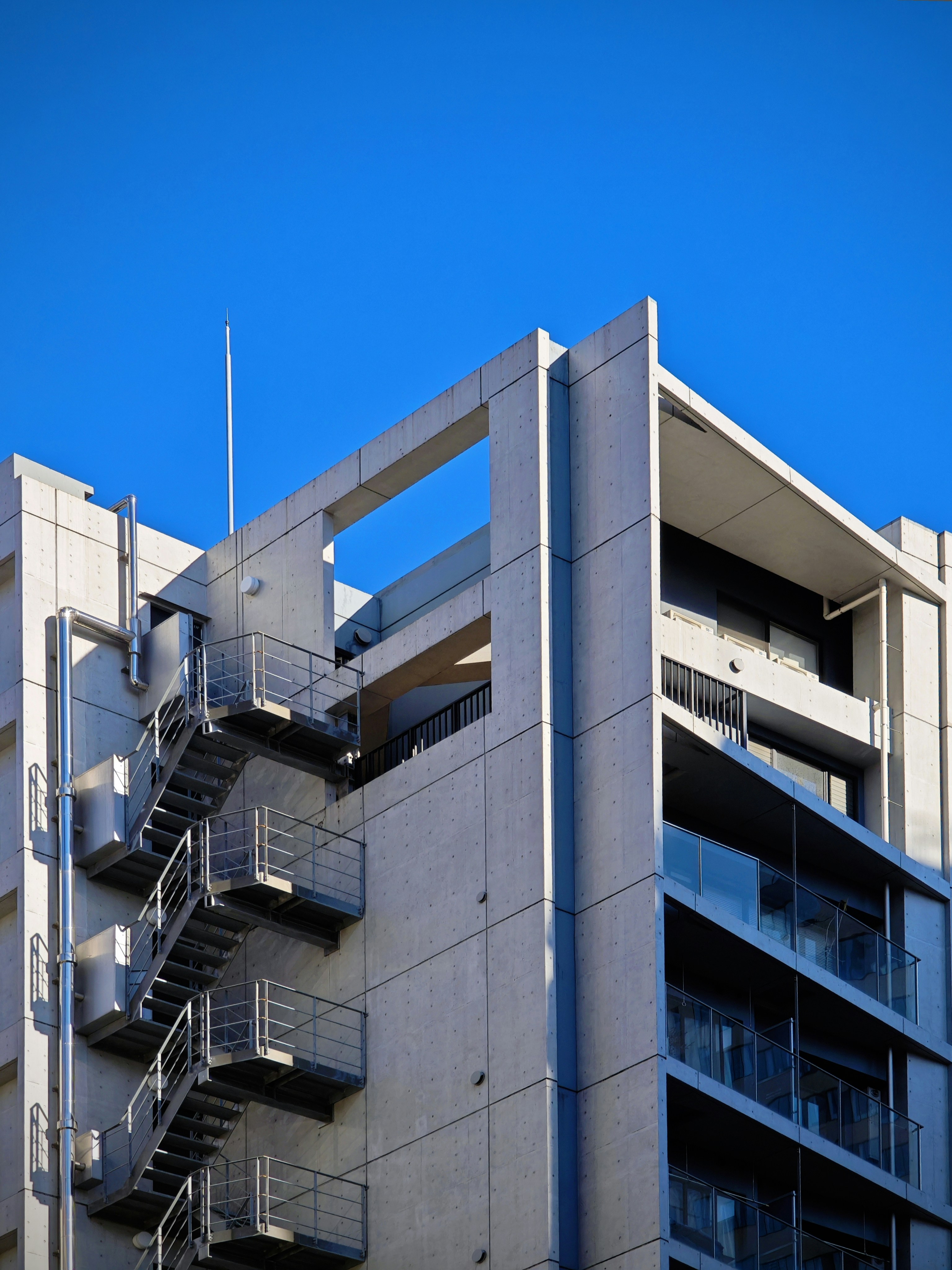Modern building with external staircase against blue sky