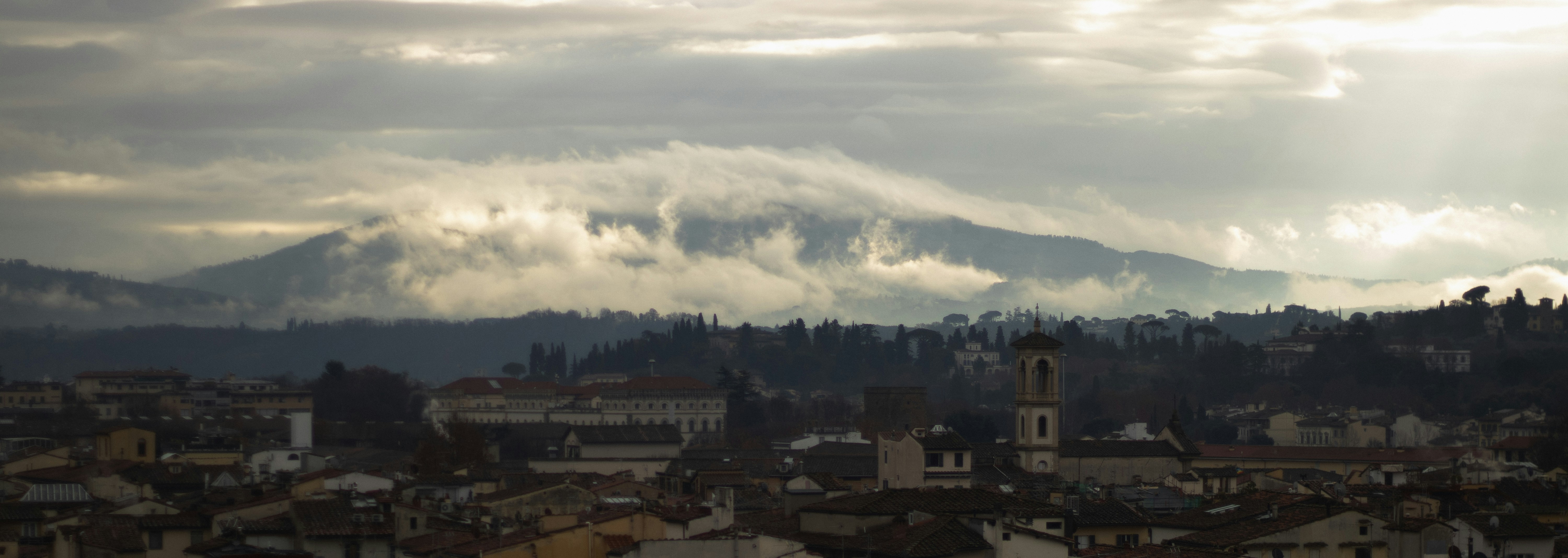 Low-Sky Cityscape with Distant Peaks and a Quiet Horizon