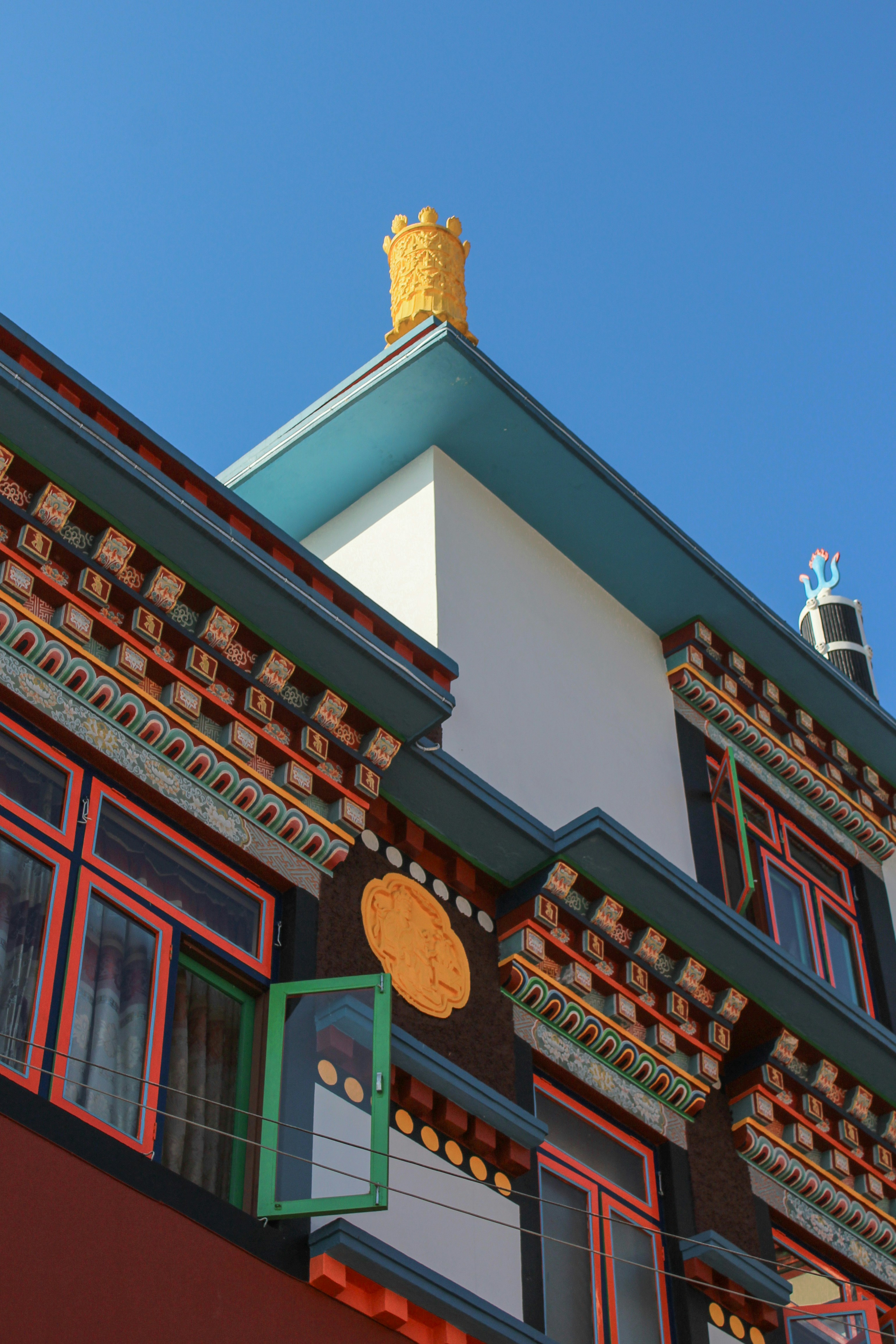 Ornate temple cornice under a clear blue sky
