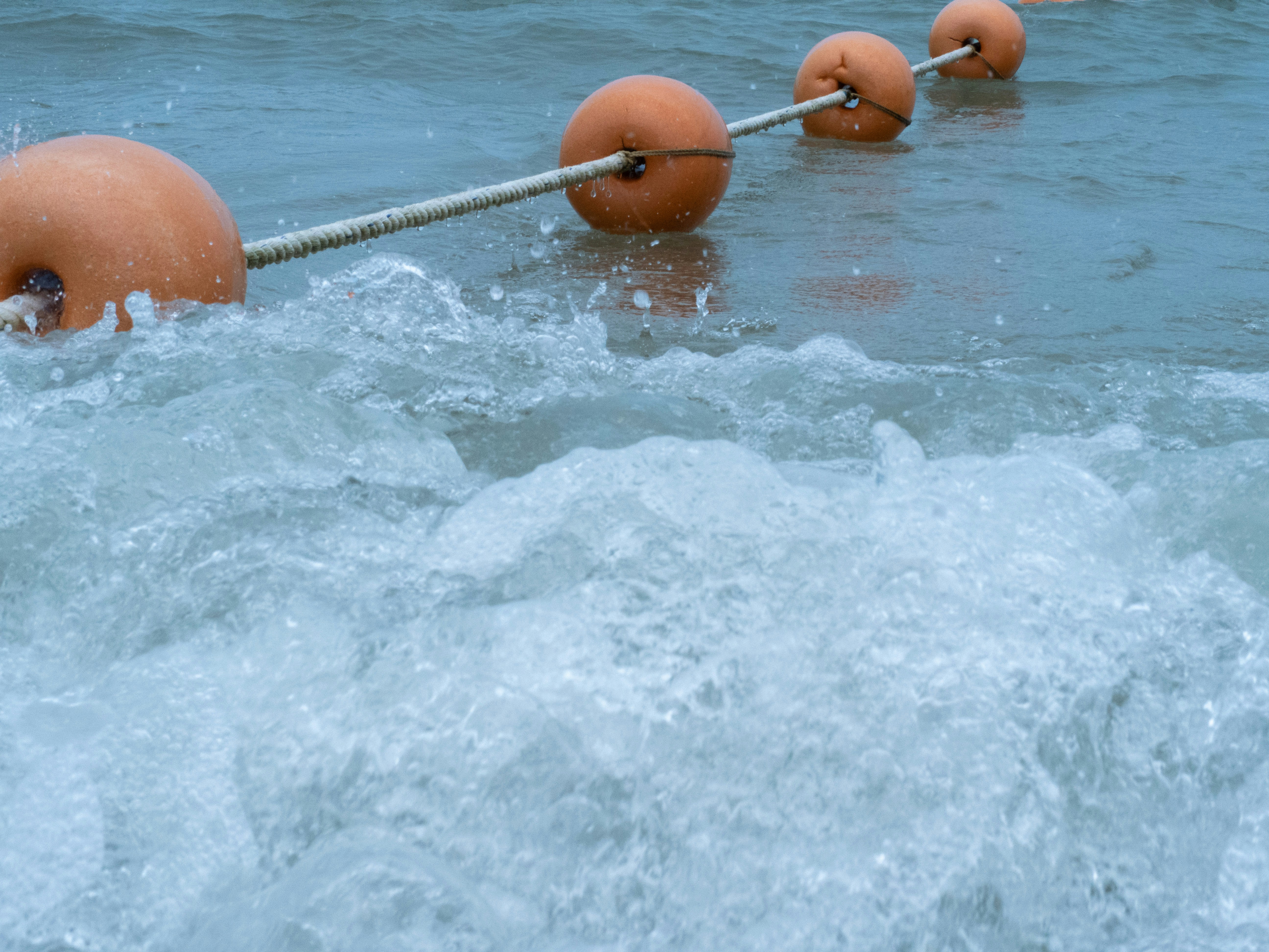 Orange buoys float on the water's surface.
