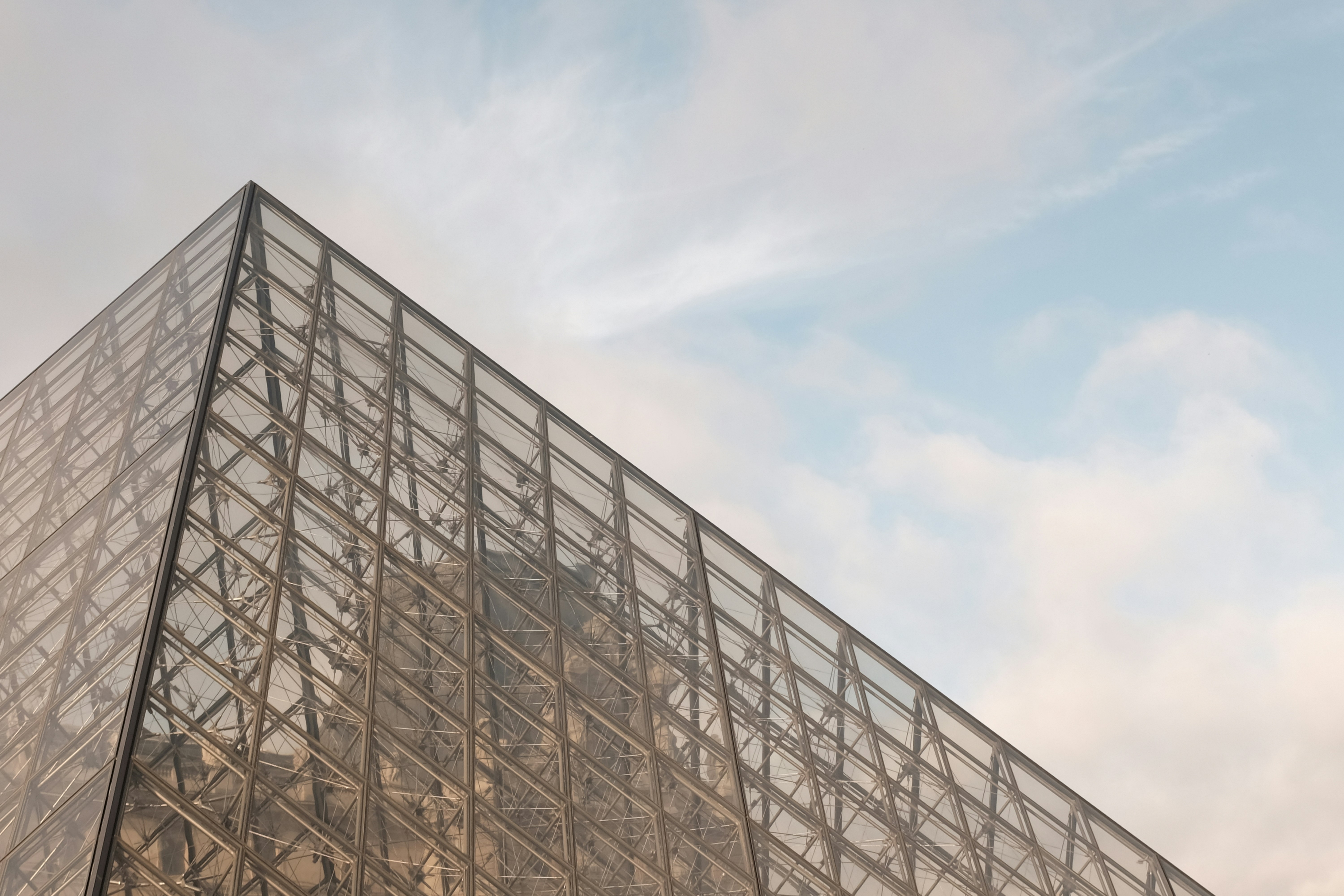 Glass Pyramid at Dusk: Geometric Facades Reaching the Sky