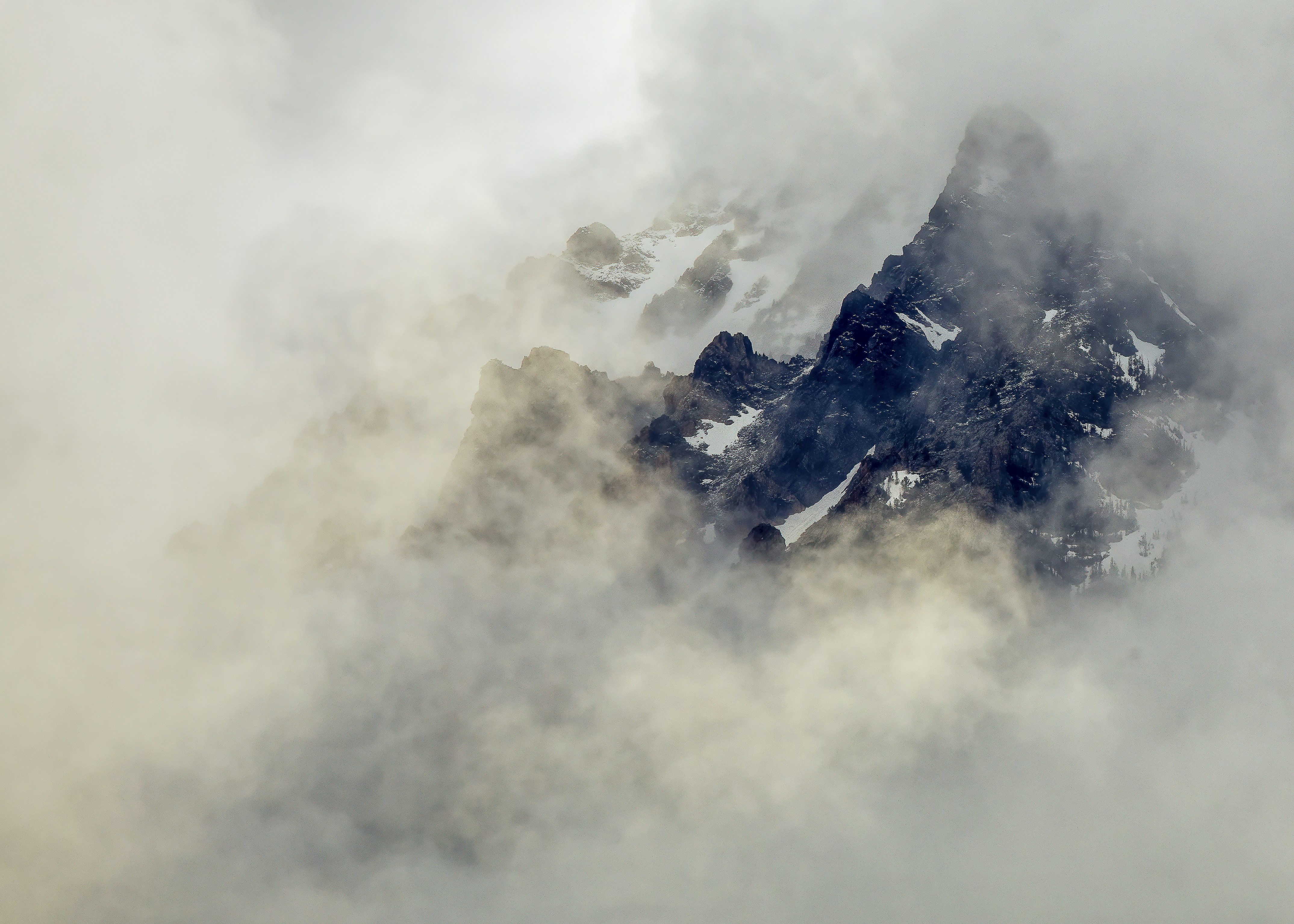 Mist-veil Summit: Snow-Wedged Peak Emerging Through Clouds