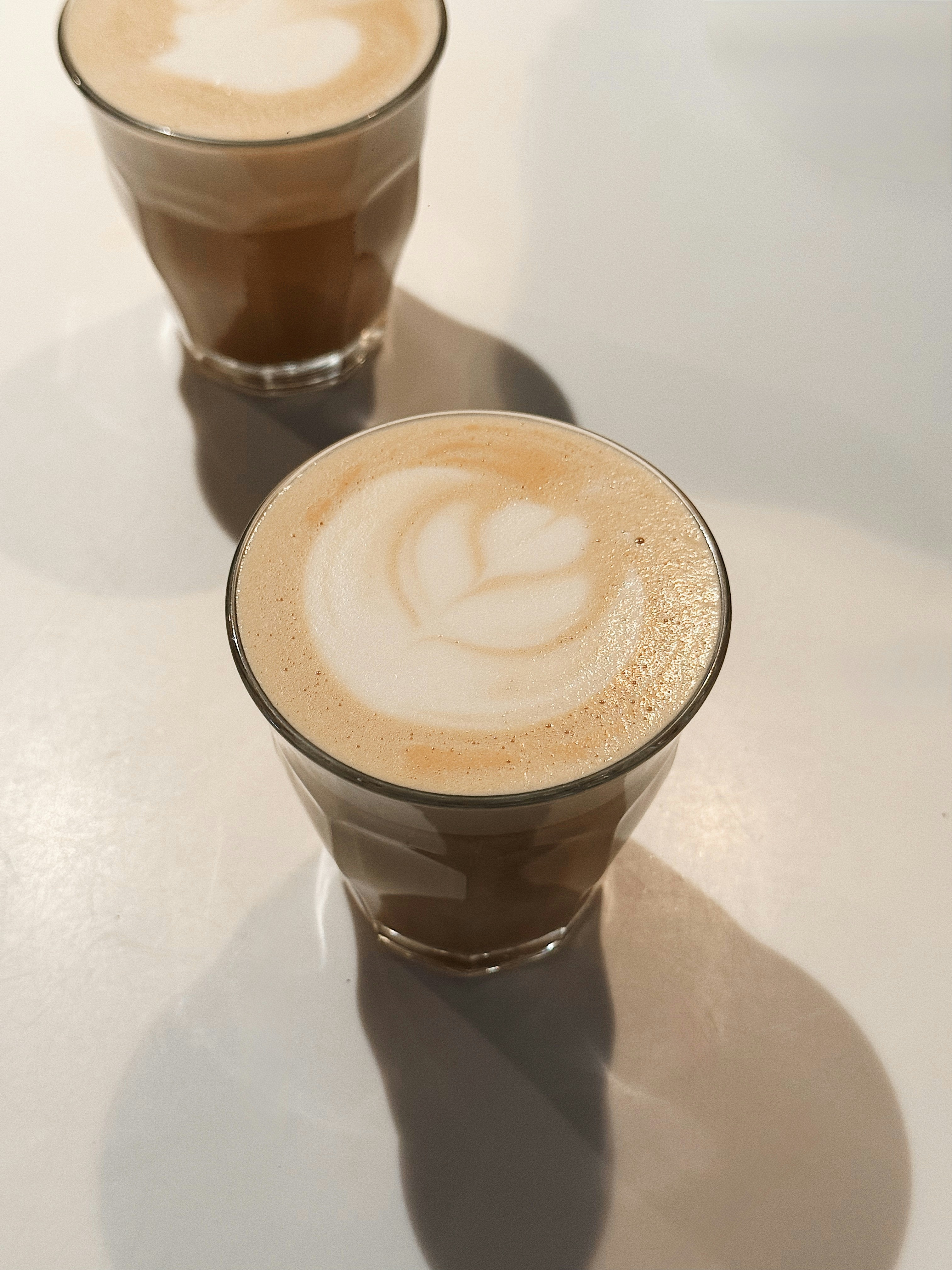 Twin Coffee Art: Latte Eyebrow Heart in Soft Spotlight