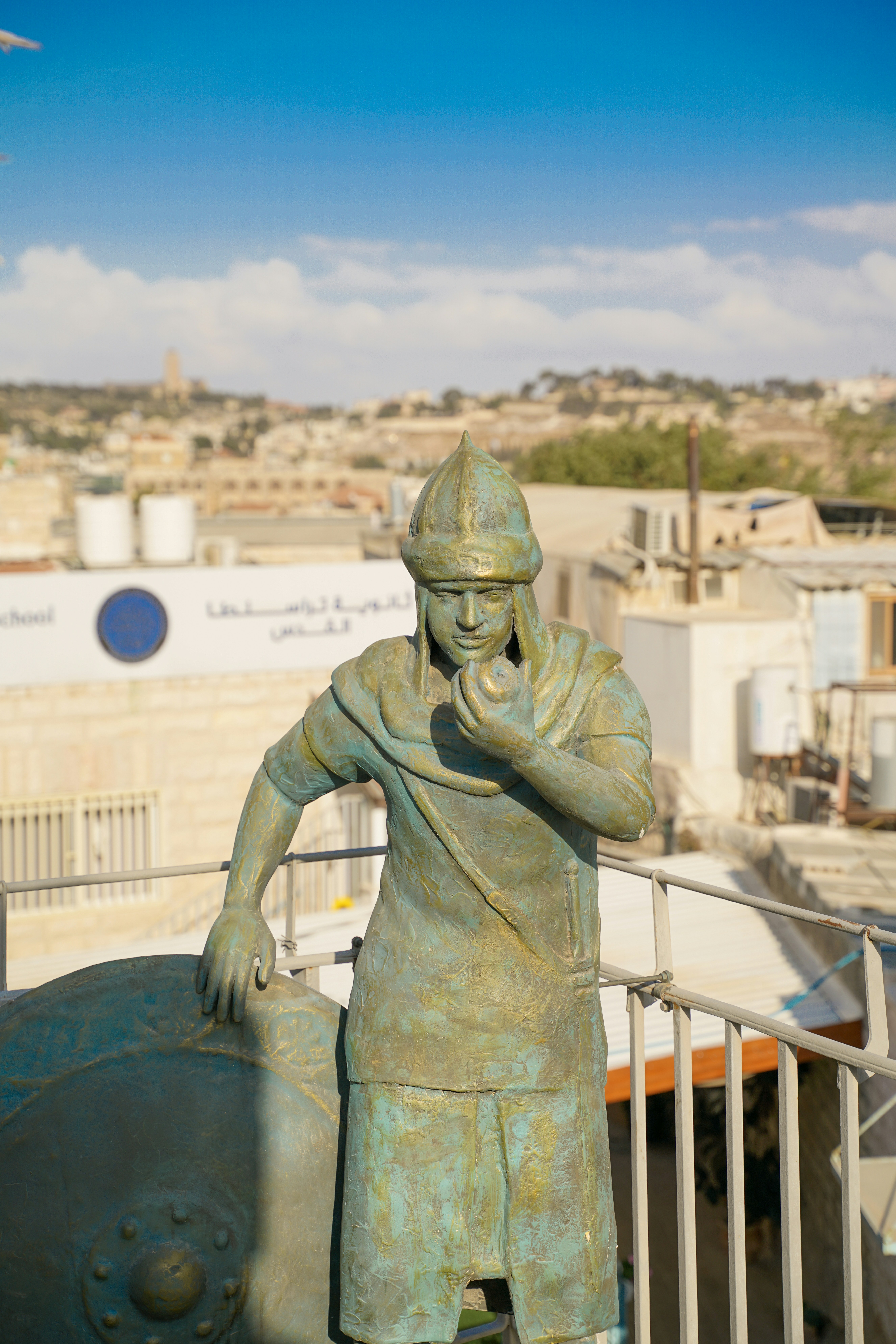 Bronze Soldier in the Sun: A Monumental Figure Against a Cityscape