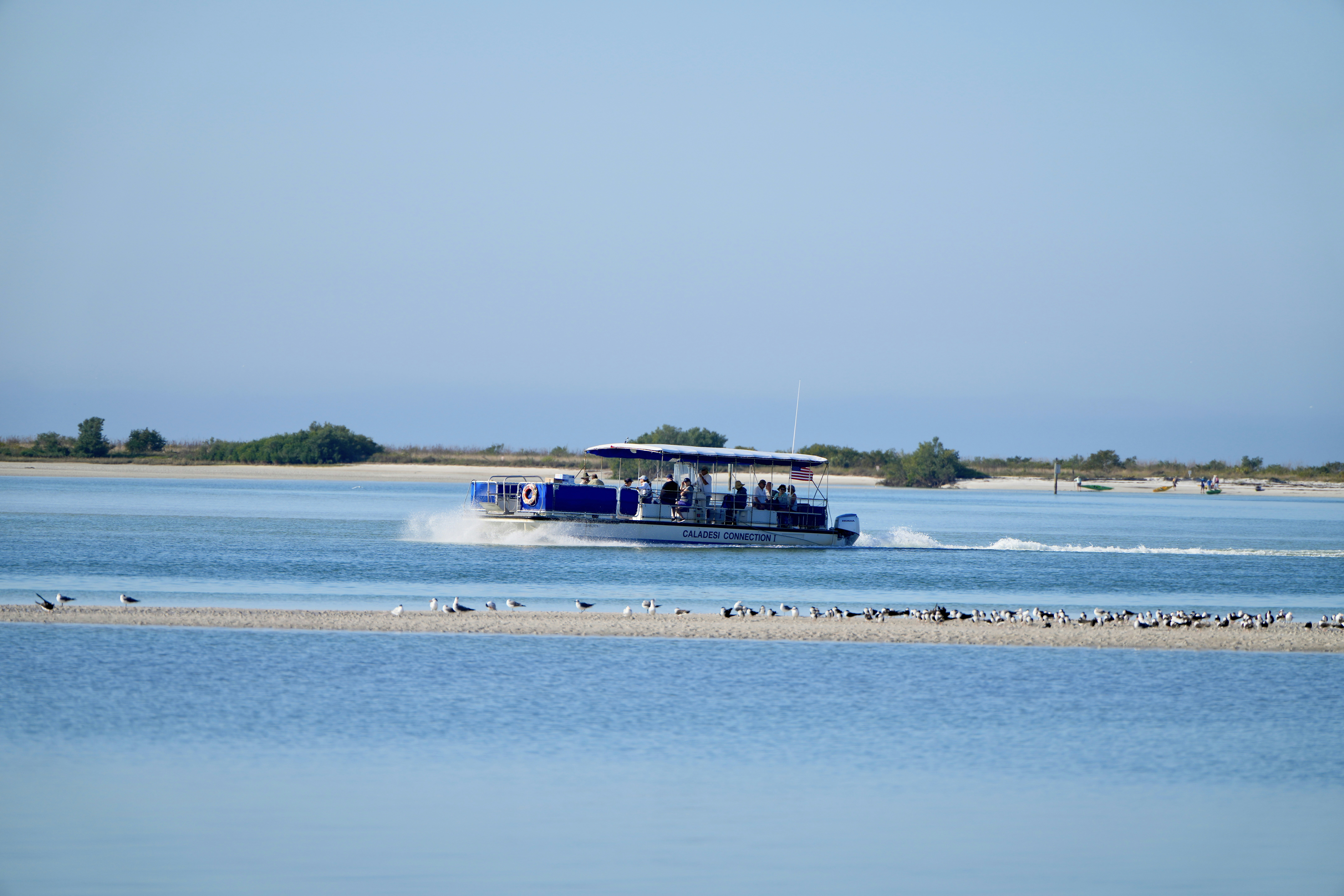 Blue-Top Boat Crossing a Calm Lagoon