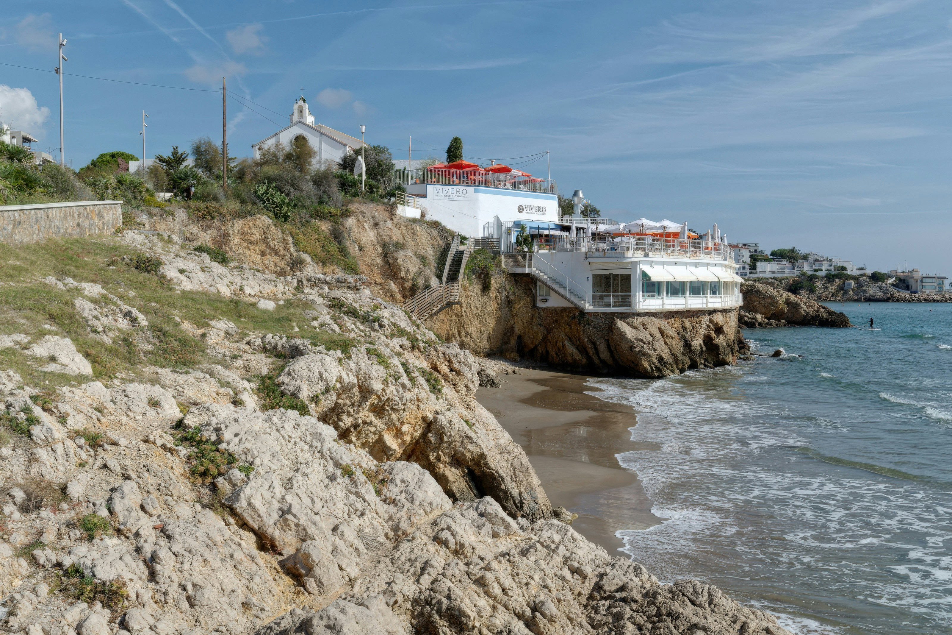White buildings on a rocky cliff overlooking the sea