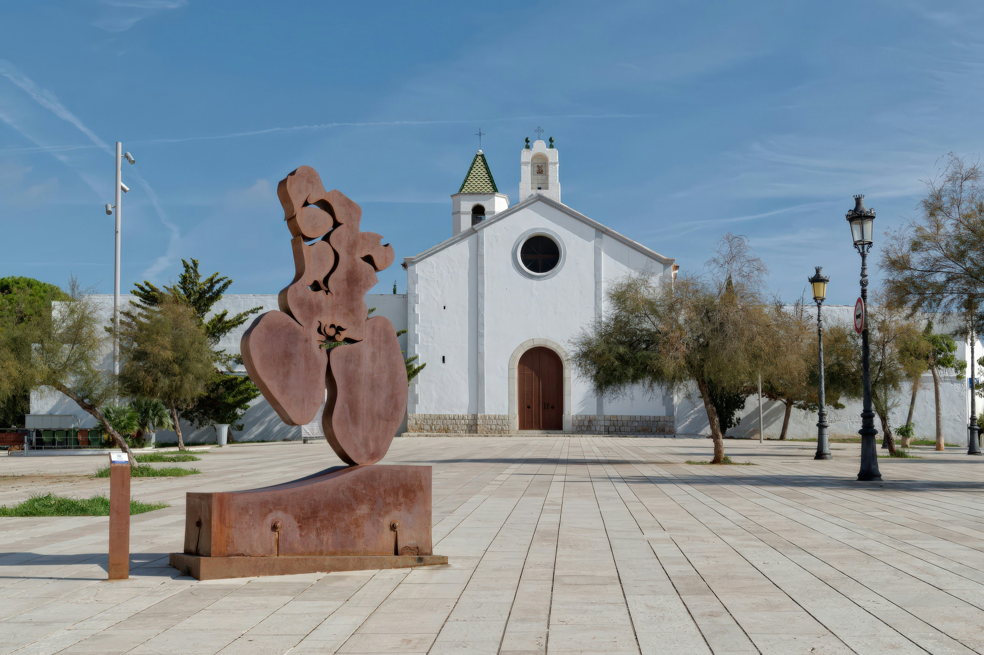 Modern sculpture in town square with church