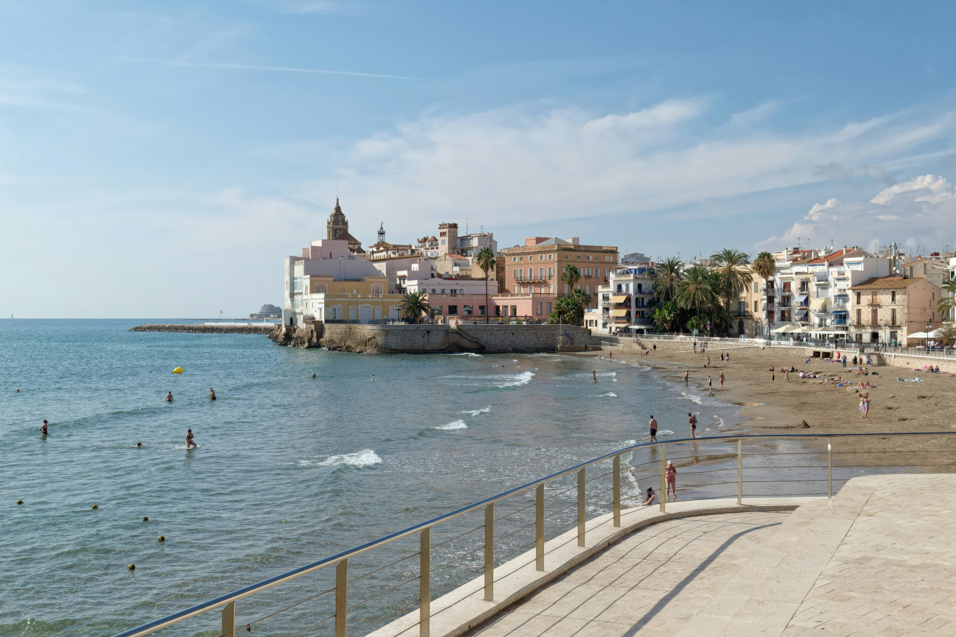 Beach town with historic buildings and calm ocean waves.