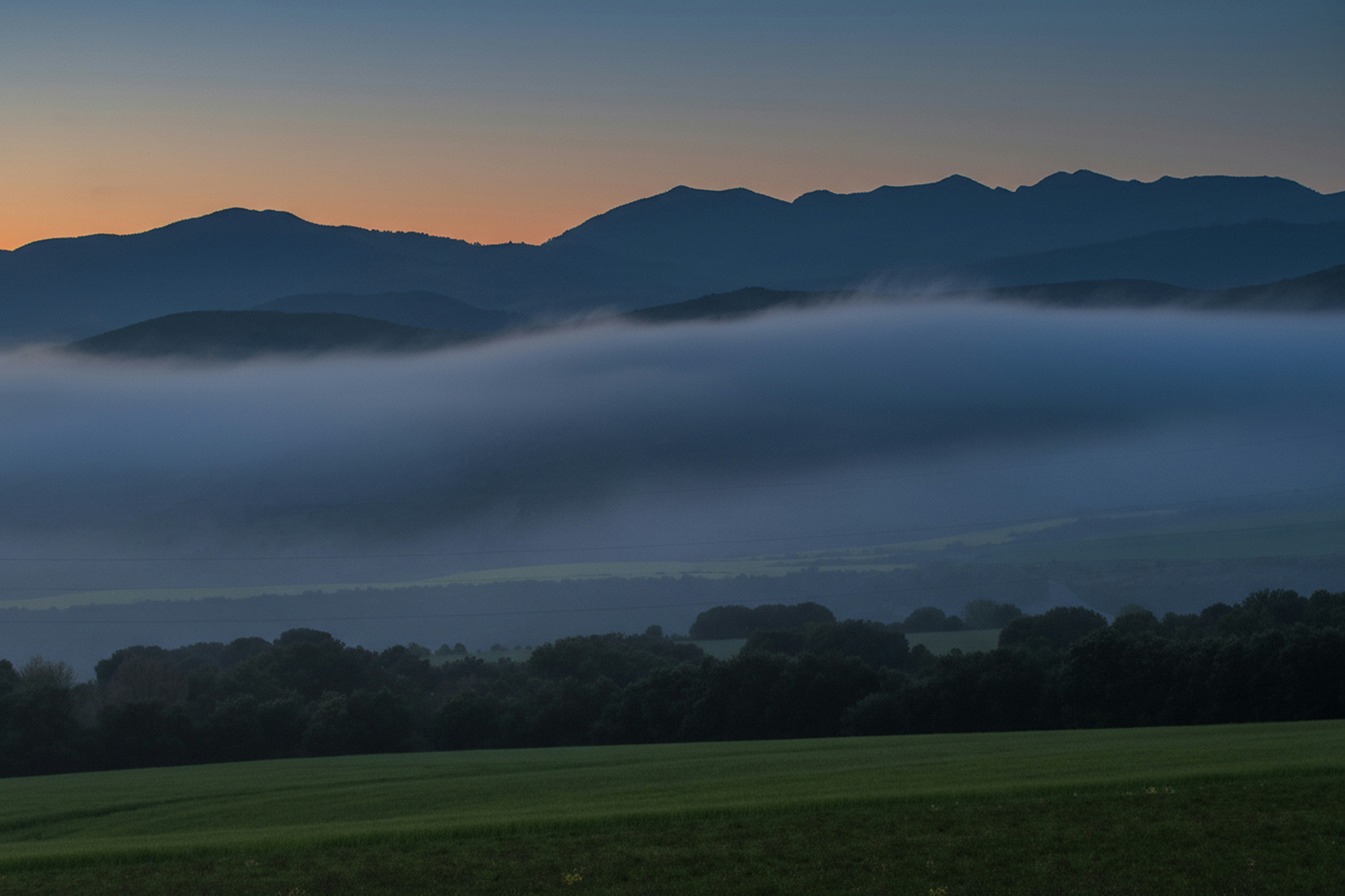 Dawn Mist Drapes the Hills Beyond a Quiet Valley