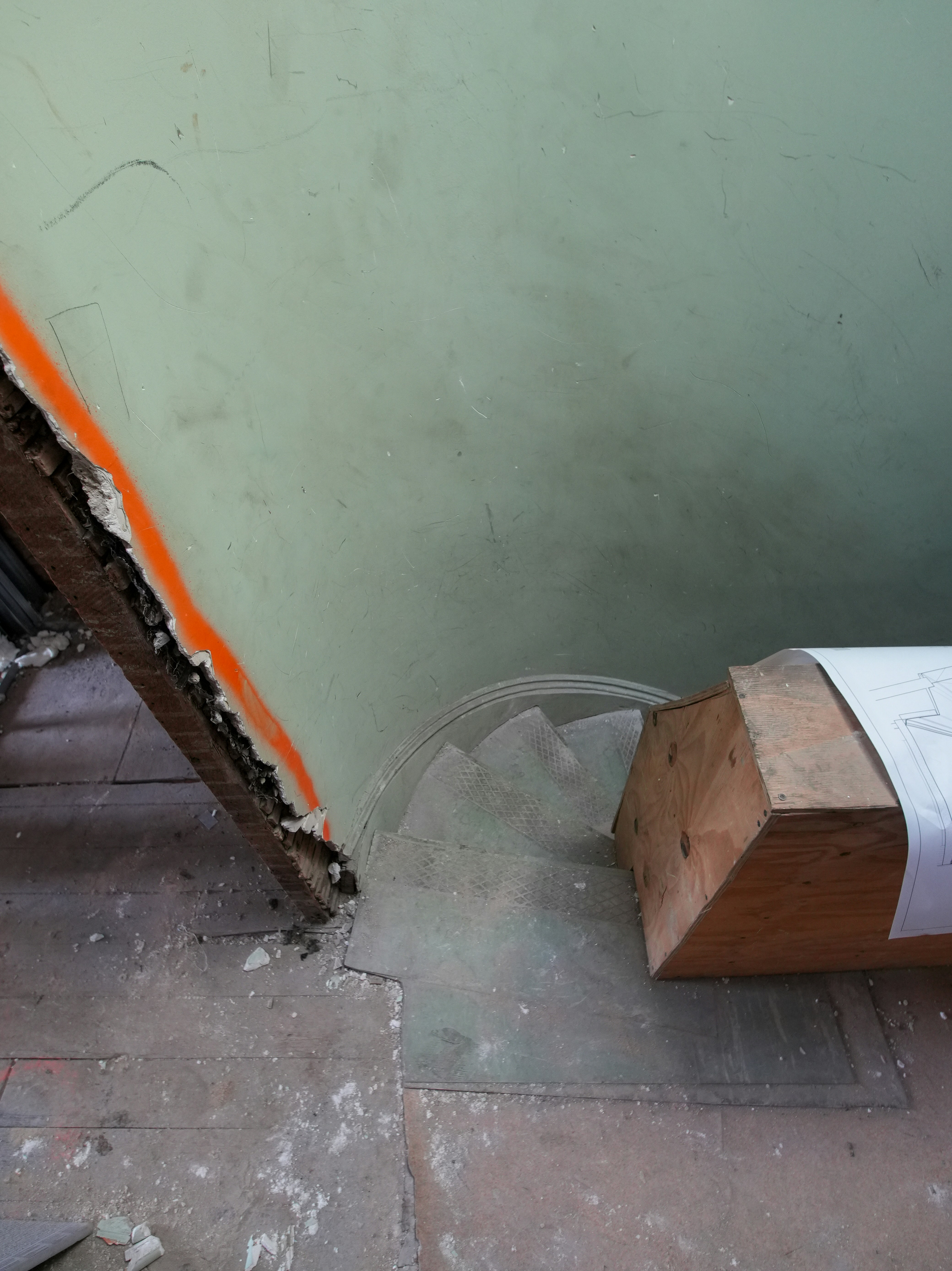 Edge of a Stairwell: Green Wall, Orange Trim, and Wooden Block
