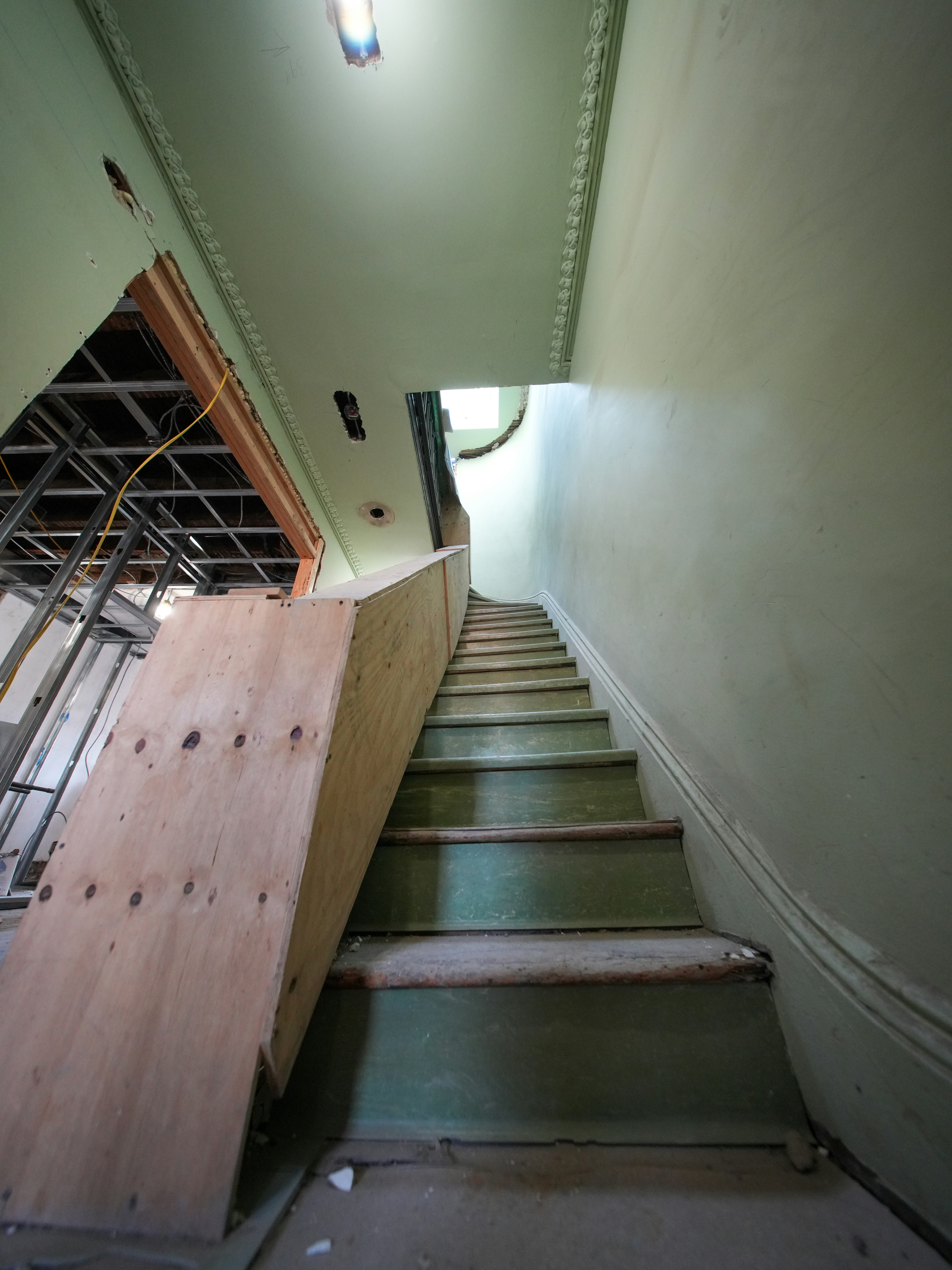 Midnight Ascent: A Worn Staircase Toward a Dim Light