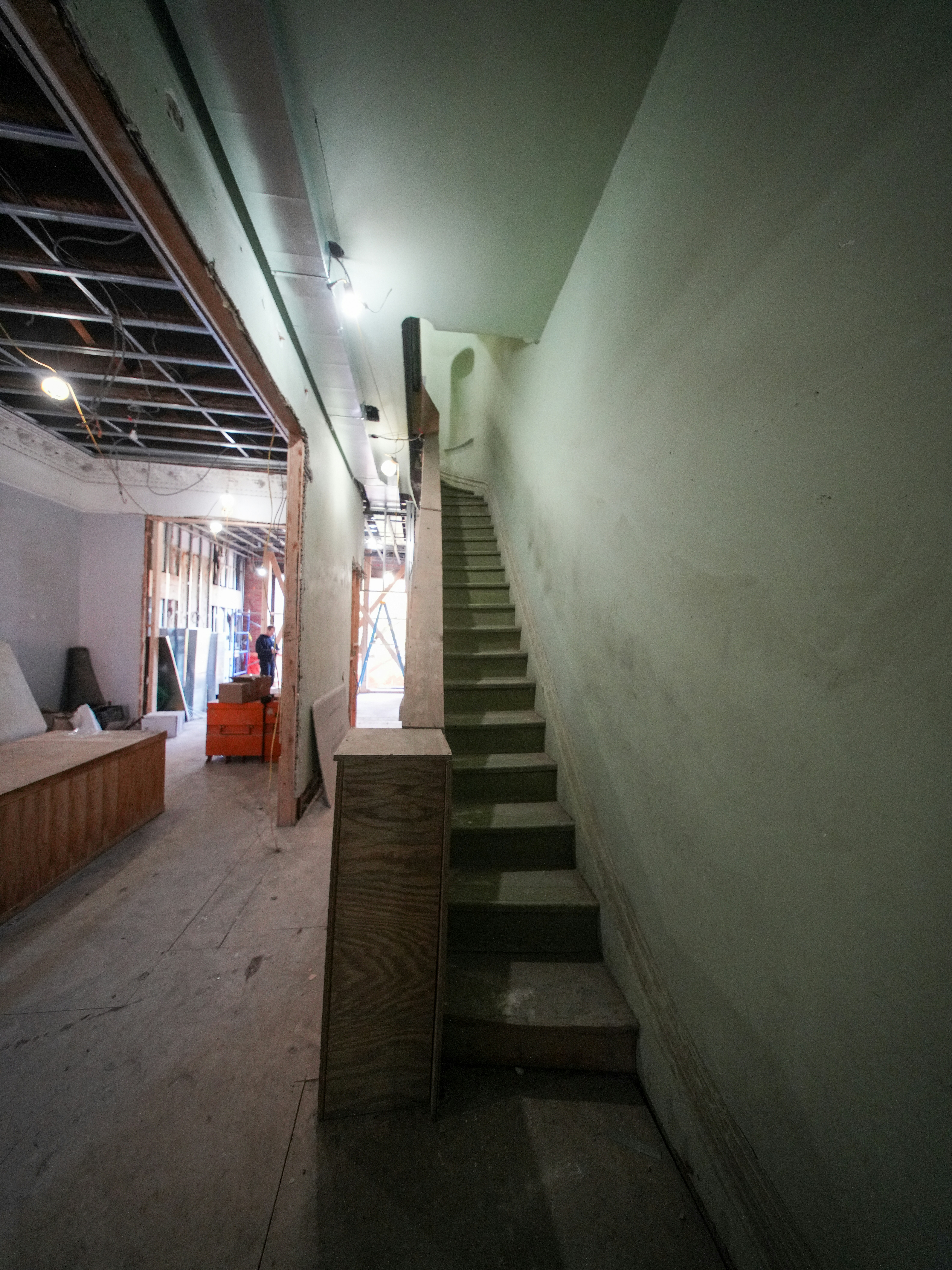 Inside the half-renovated corridor: stairs fading into construction light