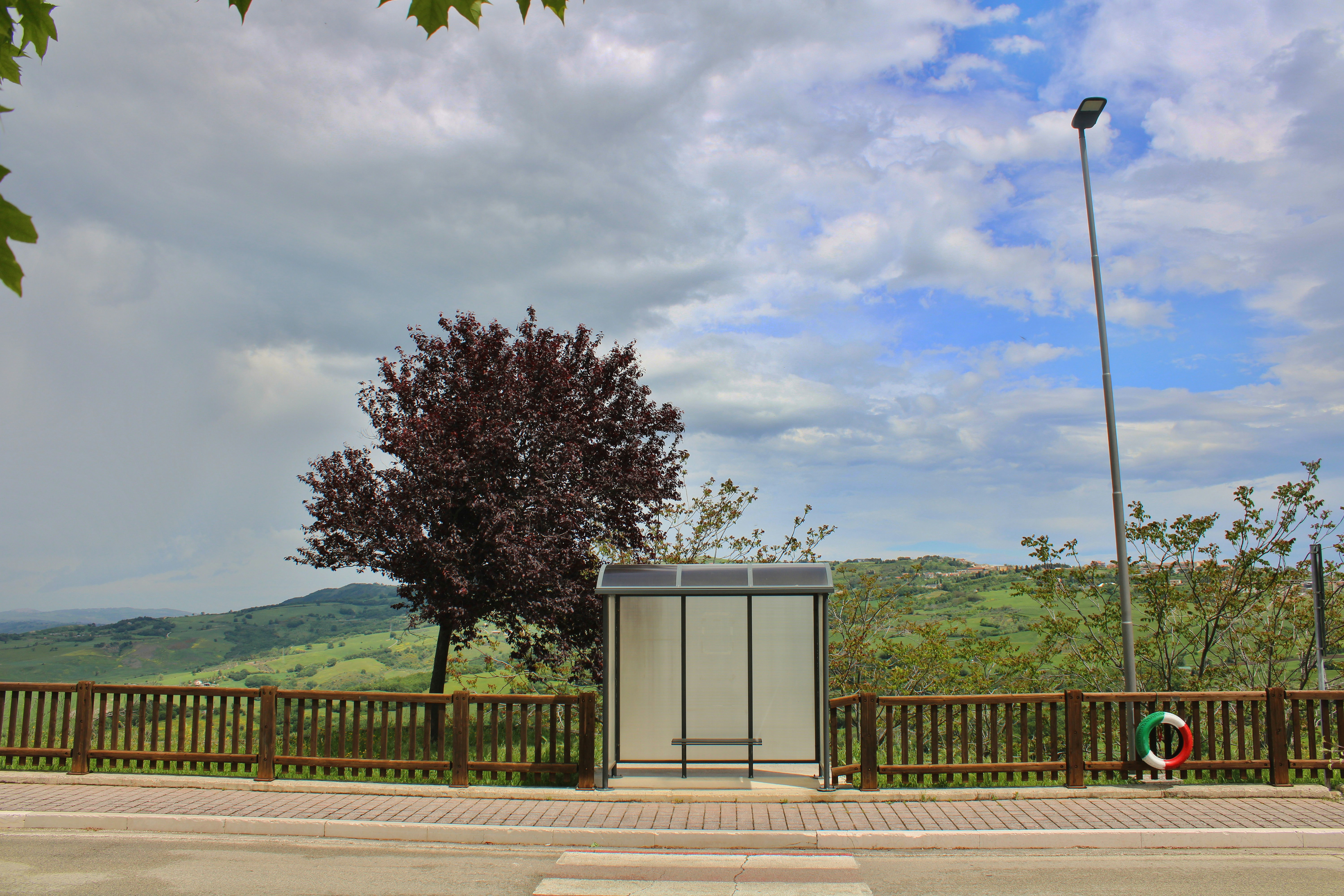 Bus stop shelter with distant landscape under a partly cloudy sky