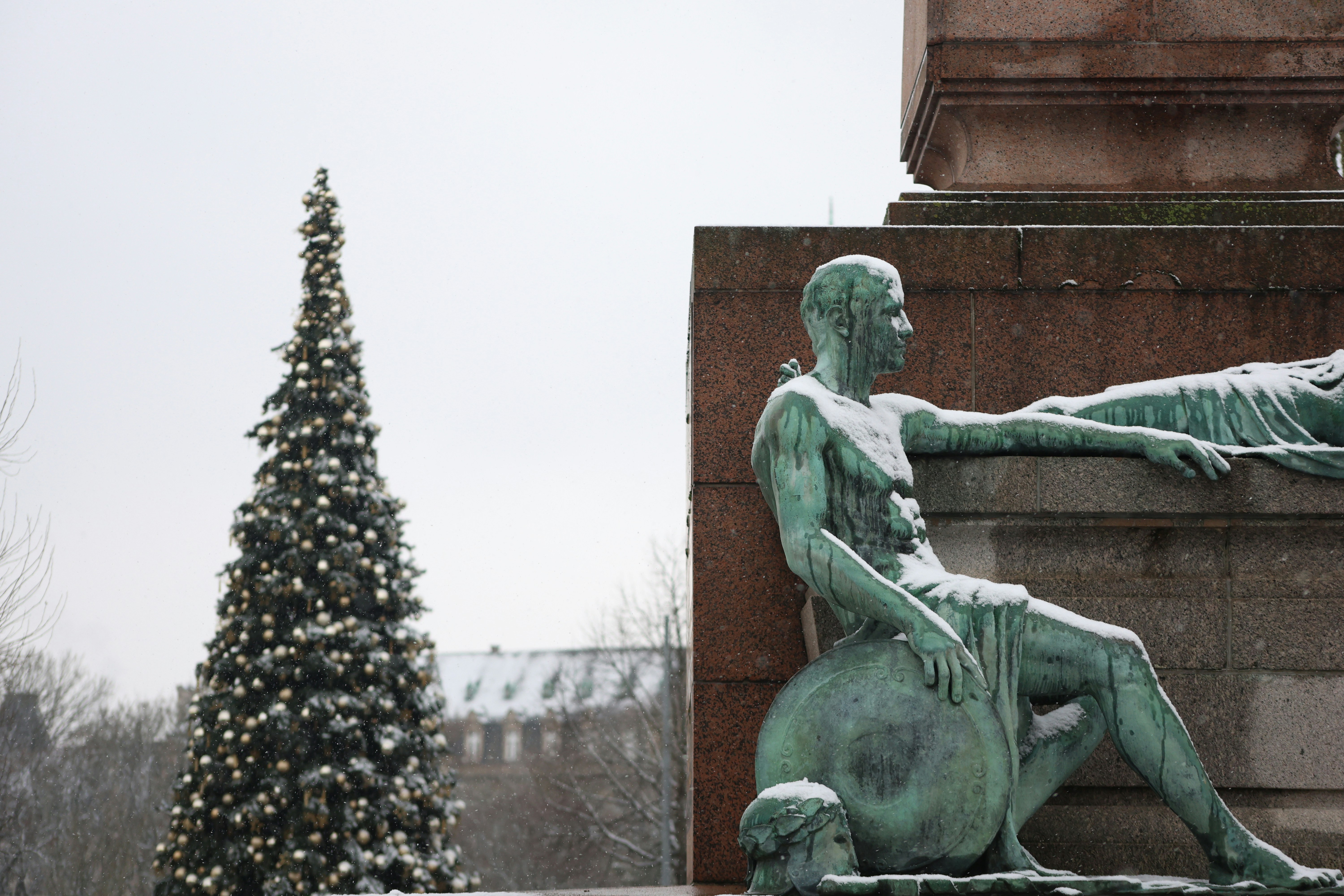 Bronze Seated Figure by Snow-dusted Monument
