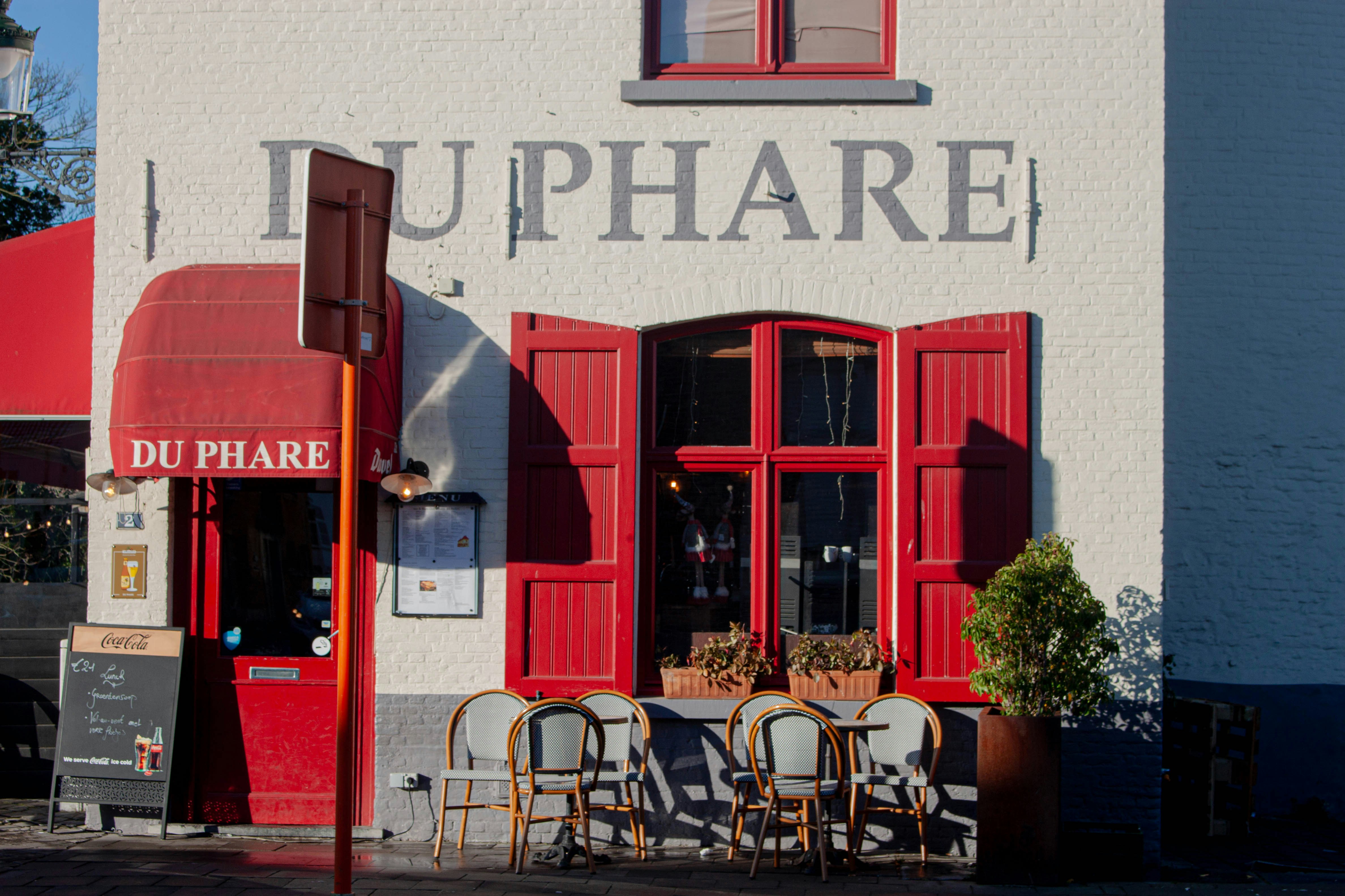 Red doors and twilight cafe: a street-side moment at Du Phare