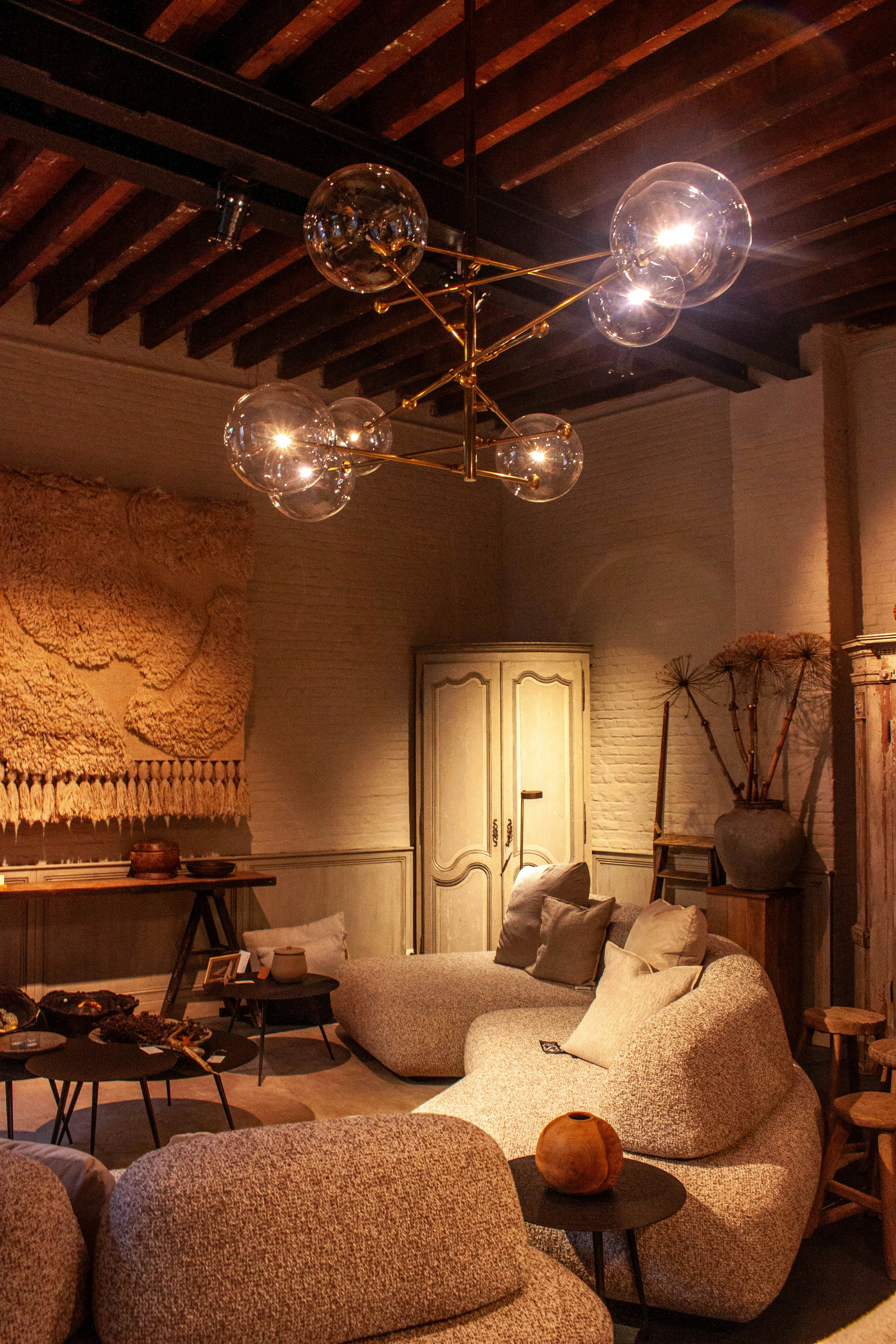 Cozy Industrial Living Room Beneath a Globe-rich Chandelier