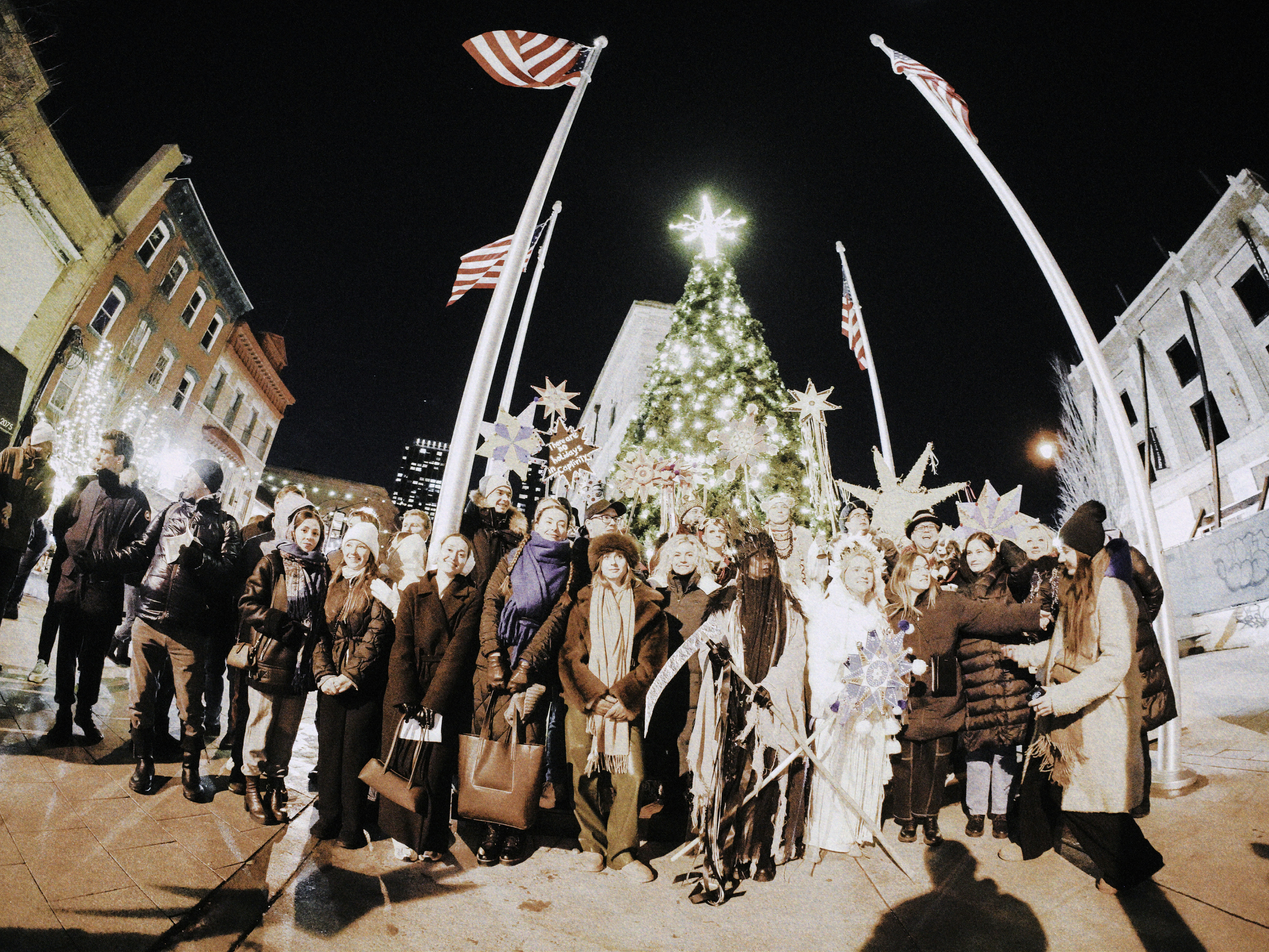 Community Holiday Luminary: A street of faces around a glowing Christmas tree