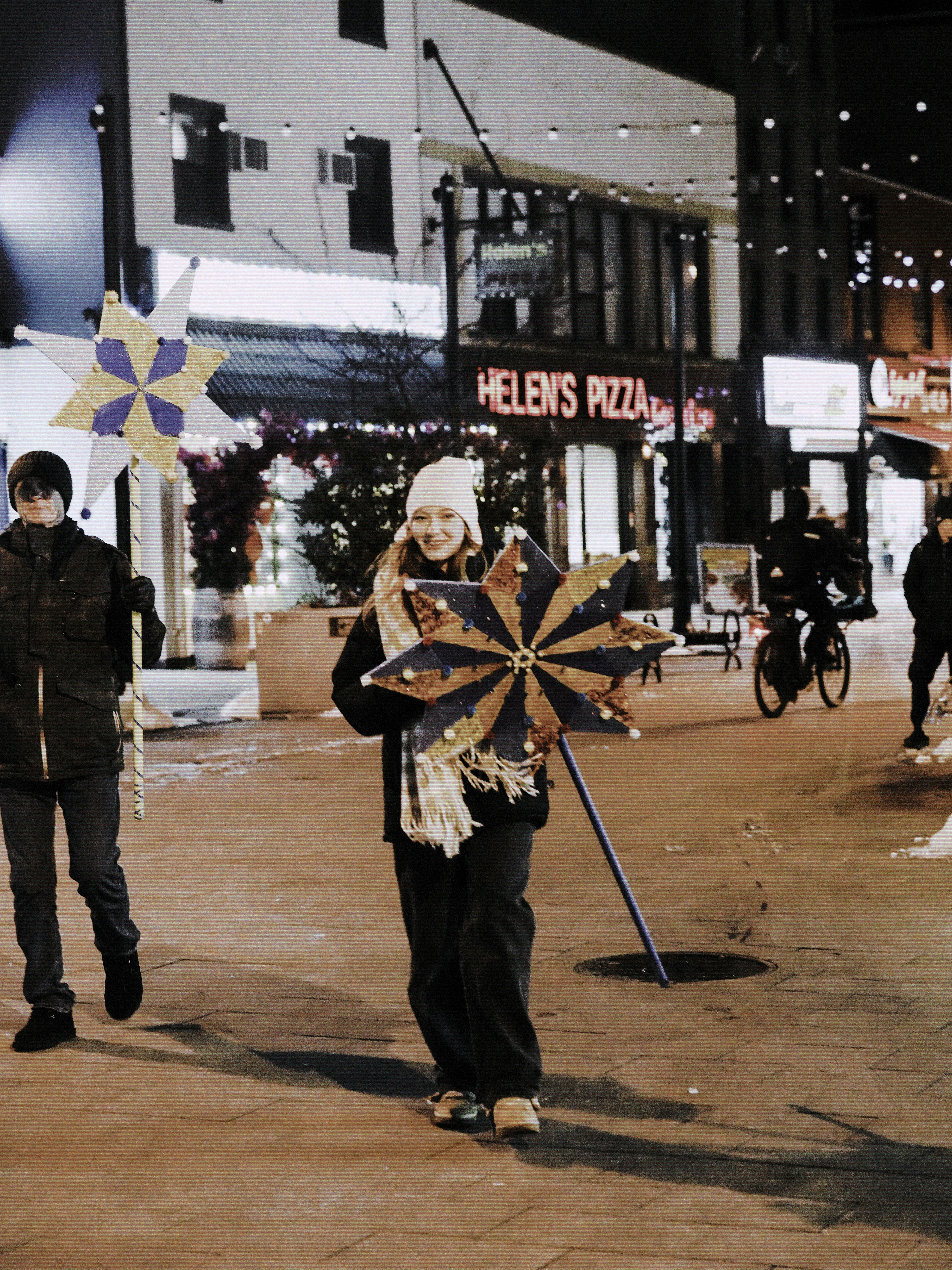Winter Street Performer with Star-shaped Lanterns on a City Night
