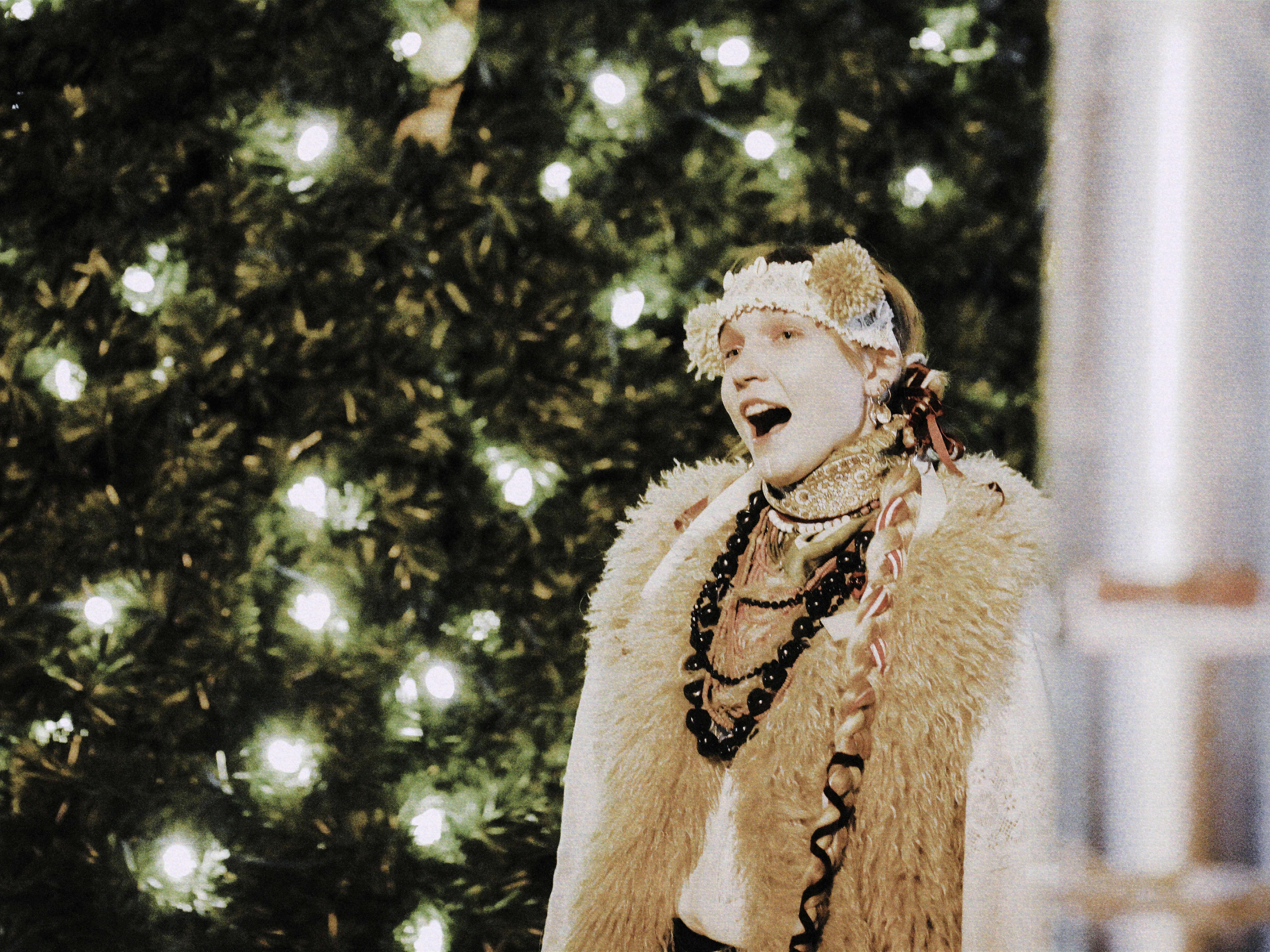 A vibrant street photography series by Olek Buzunov (@buzunov.photoart) capturing a Ukrainian Vertep folk performance in Jersey City in 2025. These images document a traditional Ukrainian Christmas procession featuring handcrafted star lanterns, embroidered costumes, ritual masks, and carolers moving through an urban American setting. Shot at night in a crowded public square, the photos blend cultural heritage with modern city life, highlighting the energy, color, and emotion of a living immigrant tradition. The collection showcases Ukrainian folklore, diaspora identity