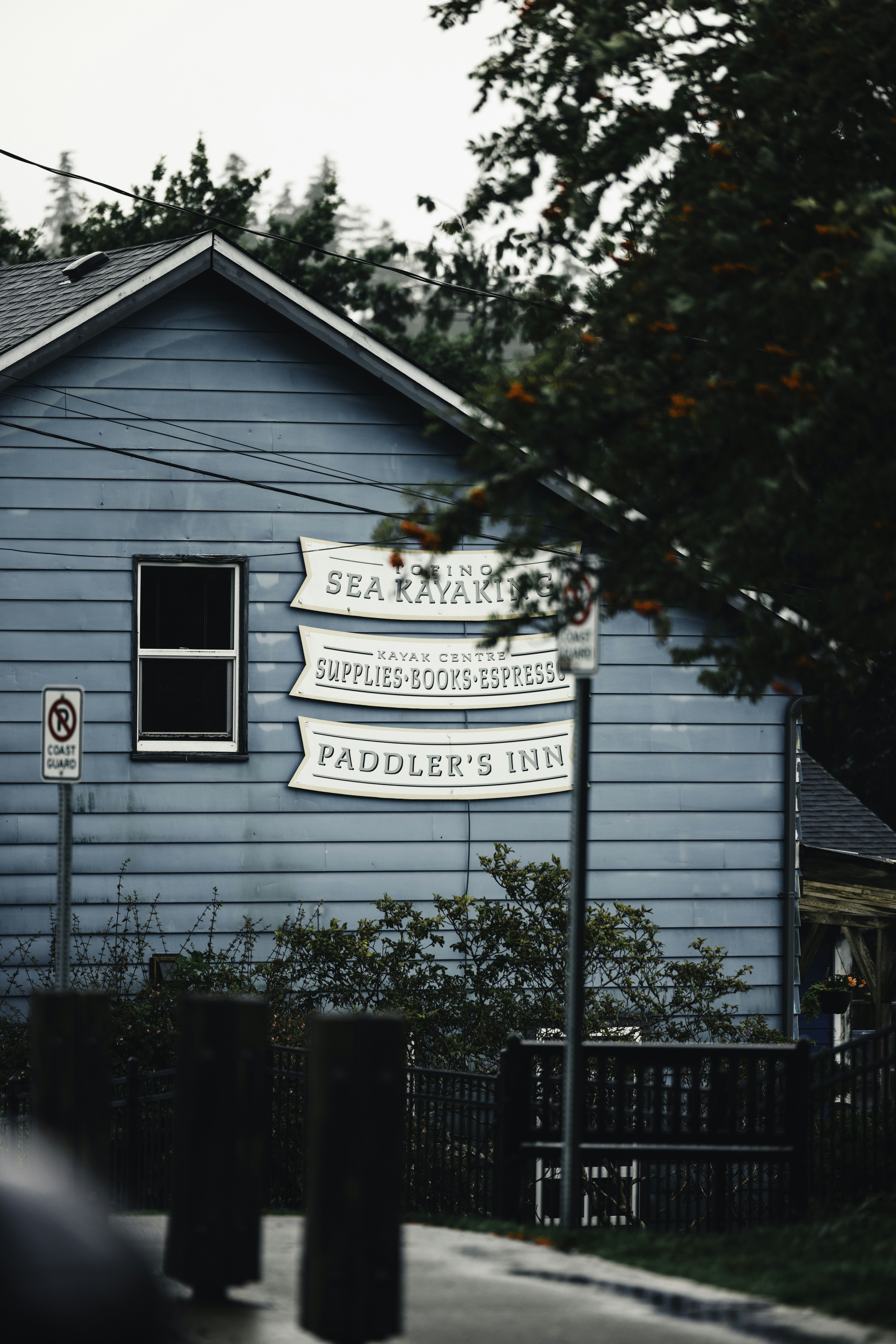 Blue wooden inn by the river with a signboard maze