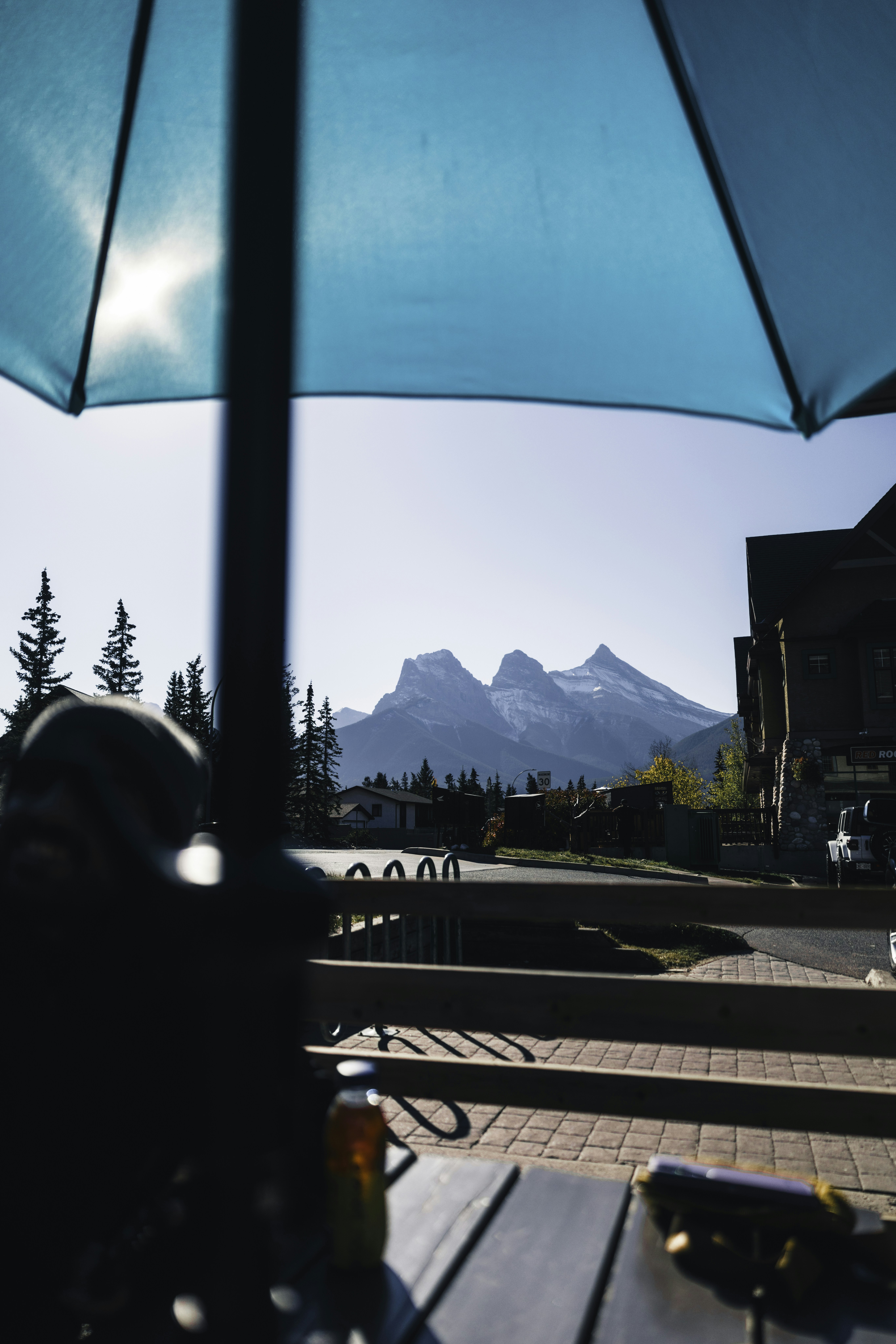 Under the Teal Umbrella: Mountain Vista from a Shaded Terrace