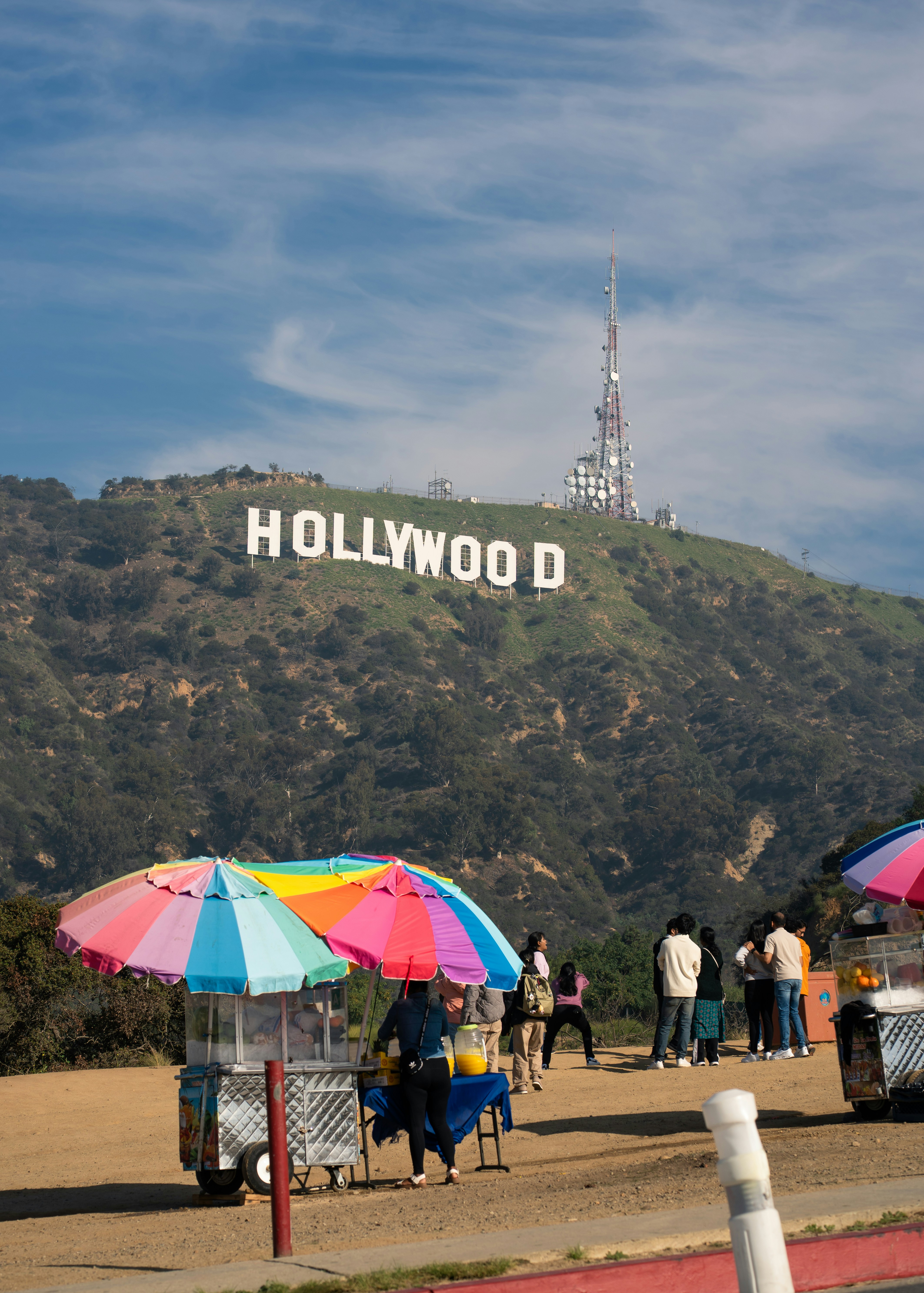 Hollywood Hill Observe: Colorful Street Vendors with the Sign Above